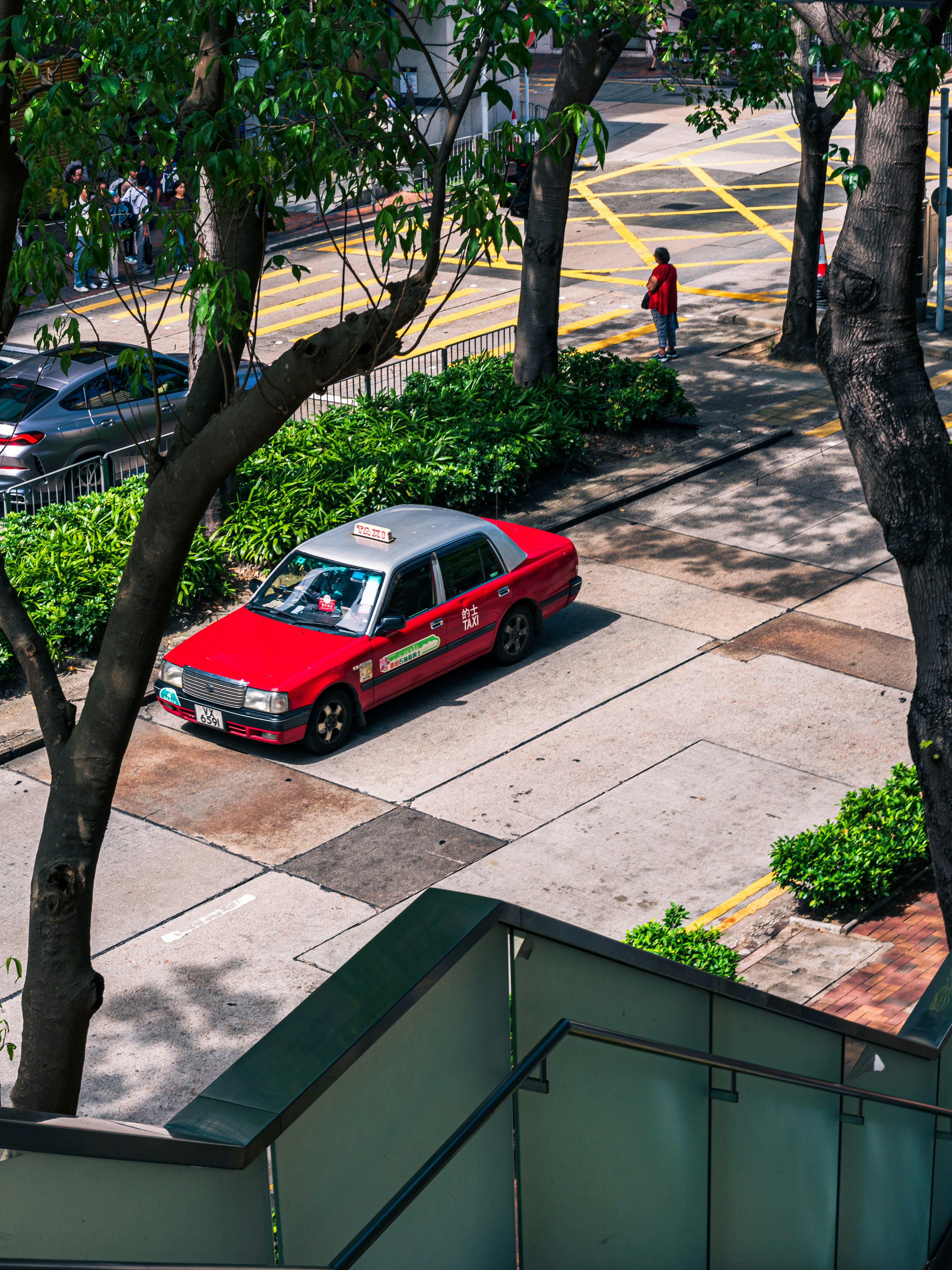 Crimson Taxi Anchors a Sunlit City Block