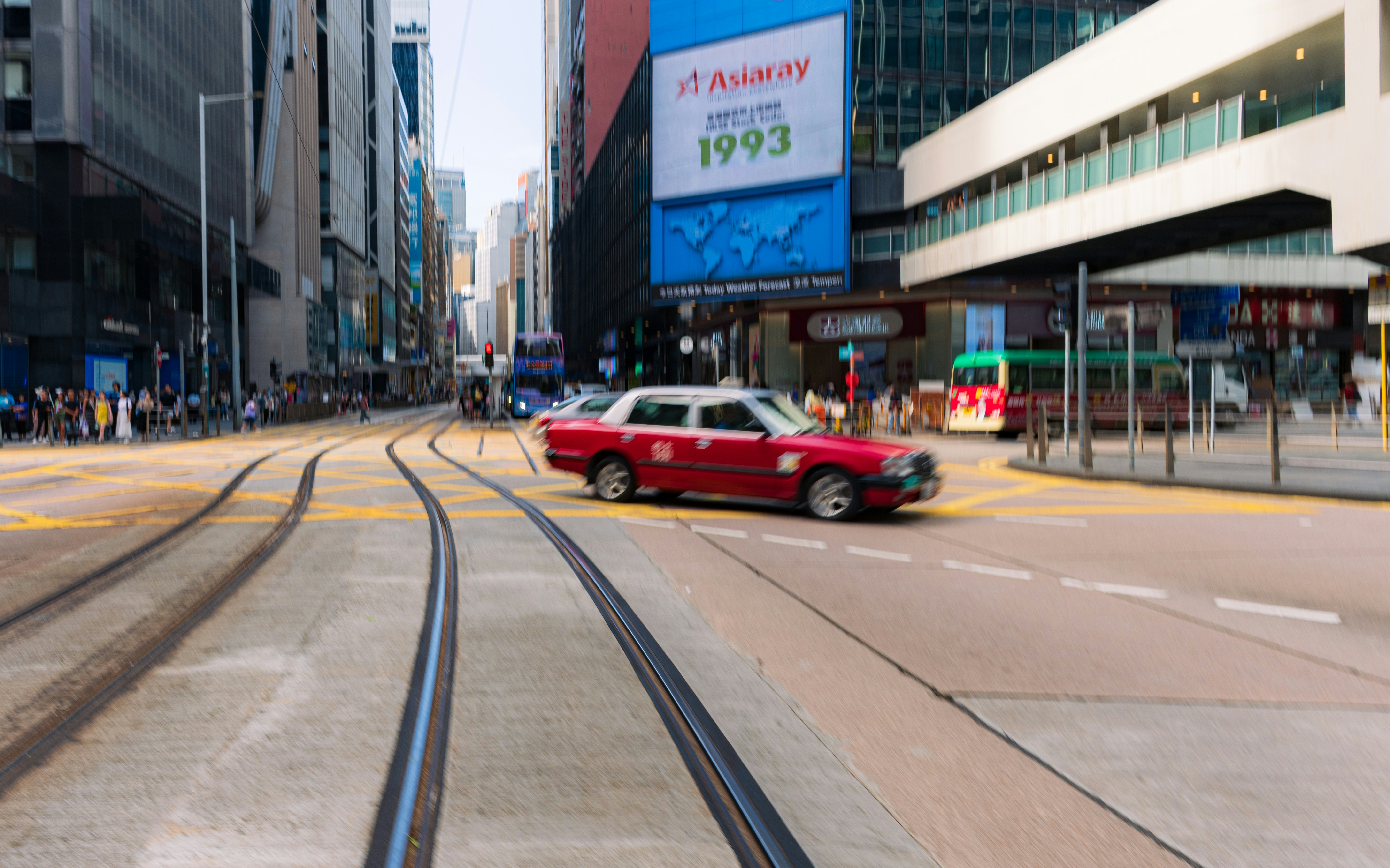 Convergence on the Tracks: A Red Taxi in Downtown Motion