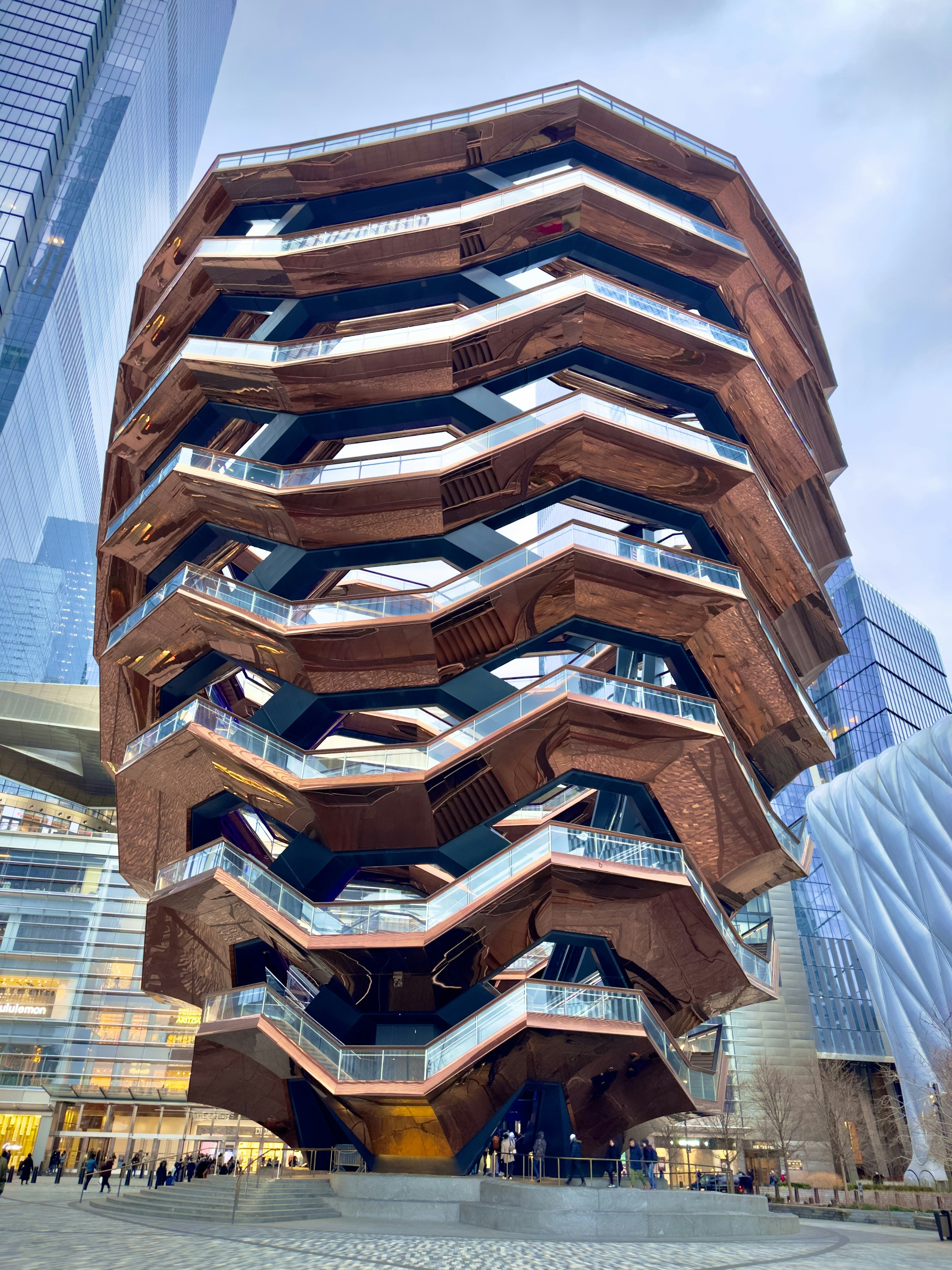 A stunning architectural honeycomb structure surrounded by visitors exploring an urban plaza in New York City Download this free HD photo of architecture, landmark, modern design, and public space in New York. Photography by Parthvi Gor @wanderveg Free to use under the Unsplash License | The vessel structure in new york city.