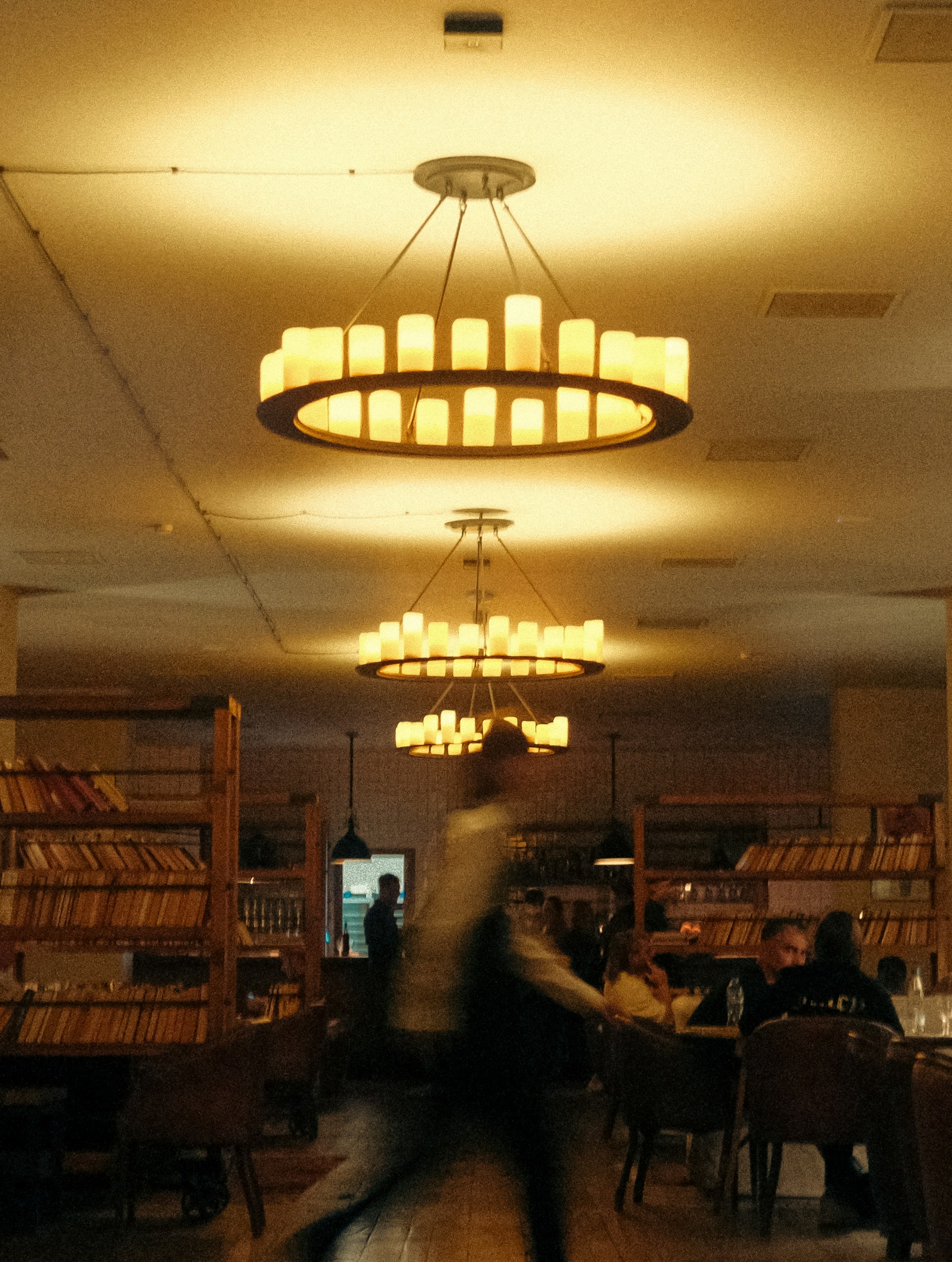 People in a library with chandeliers and chandeliers photo – Free ...
