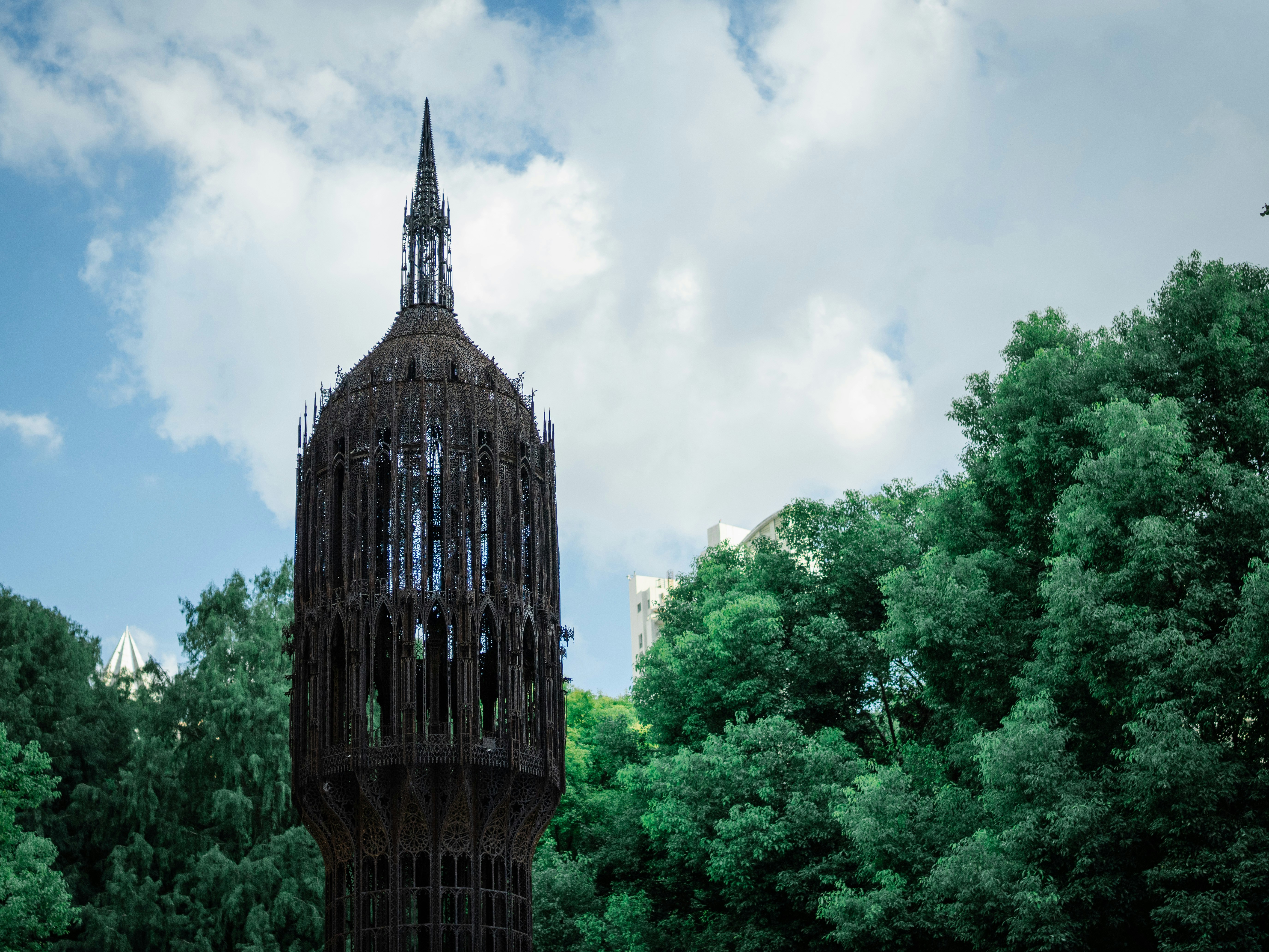 Iron Lace Spire Rising Through Summer Canopy