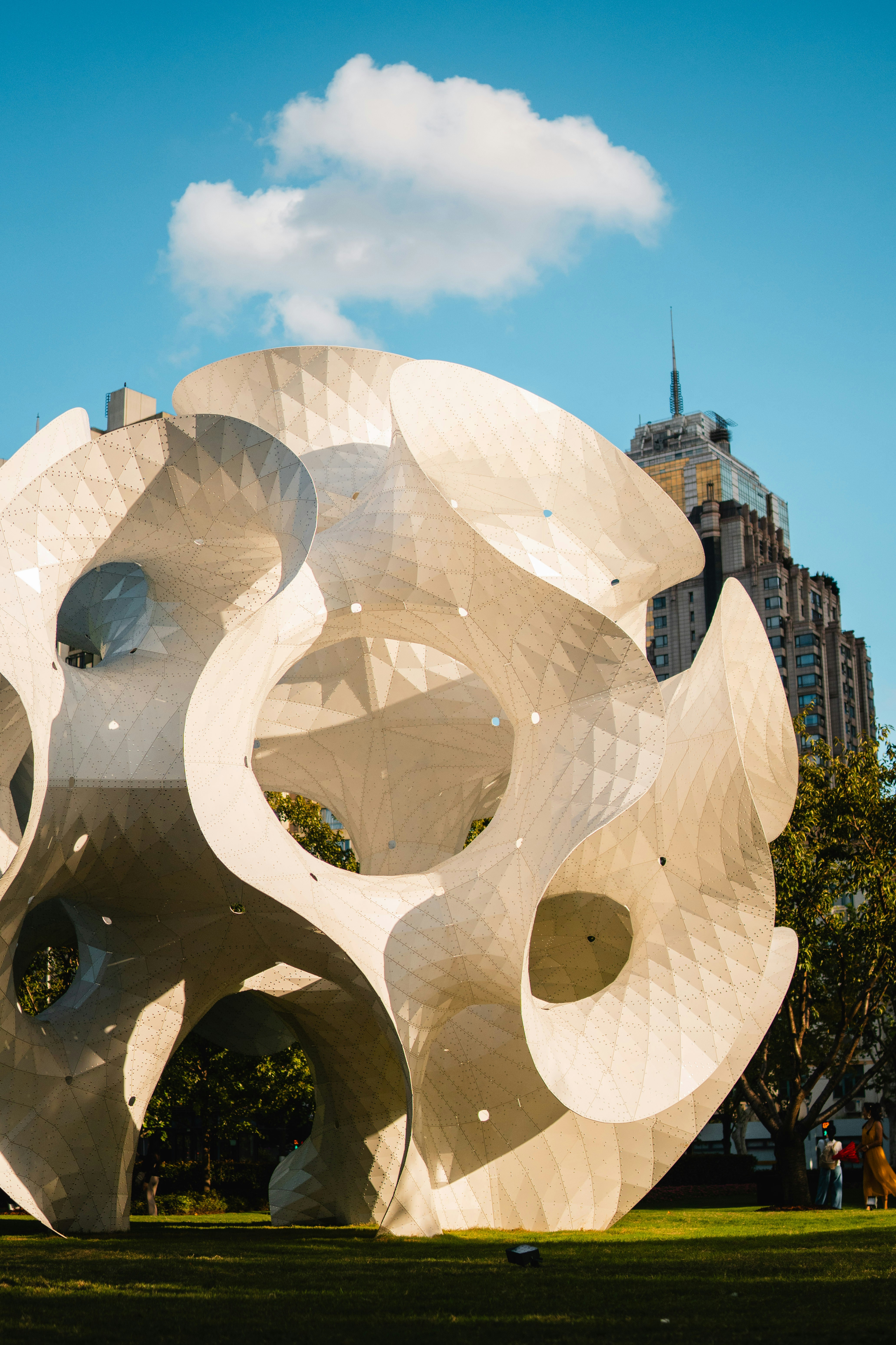 Curved Lattice in the Sun: White Sculpture Meets Cityscape