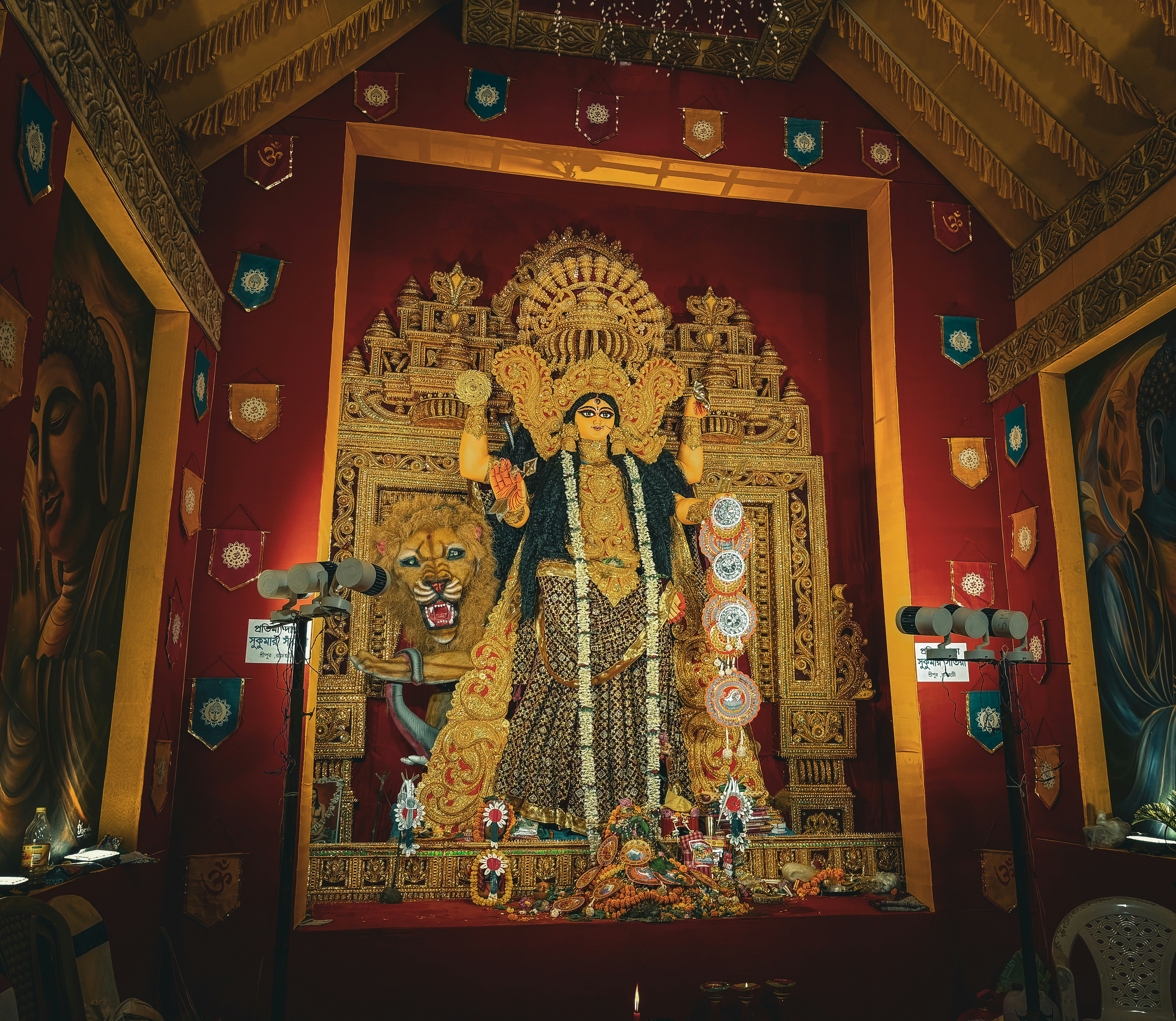 Ornate idol of durga with lion decorated in red temple.