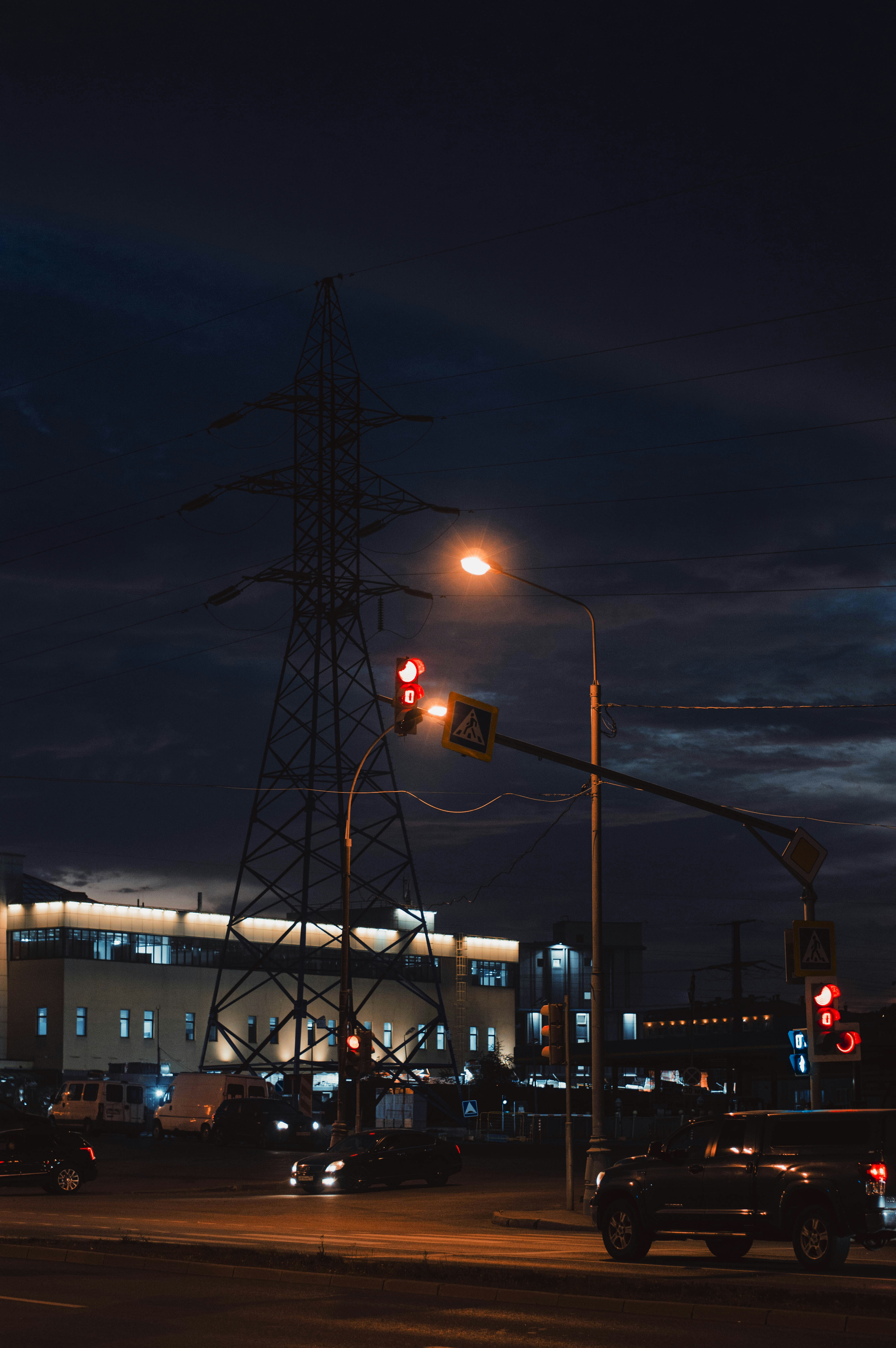 City street at night with traffic lights and power lines.