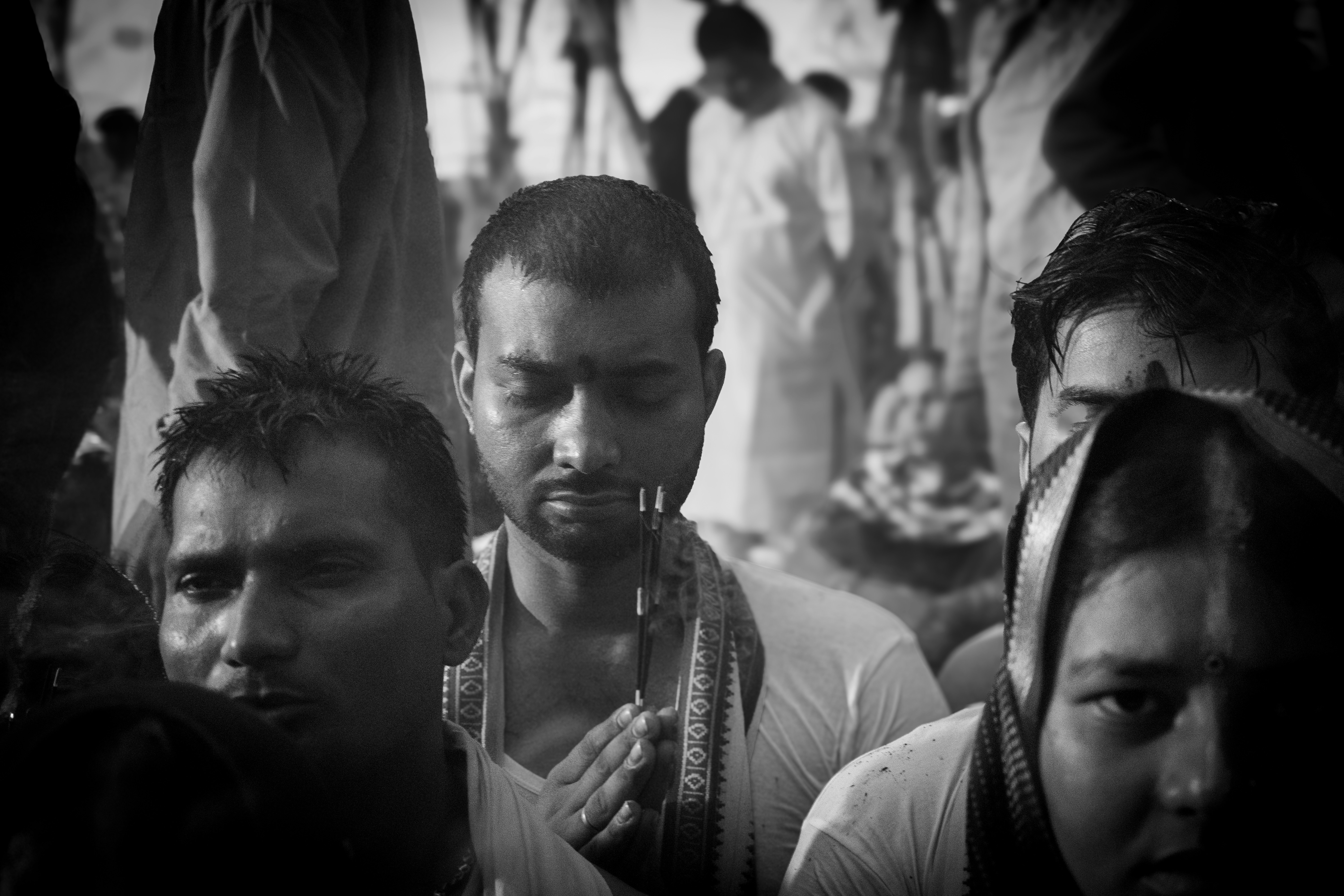 A group of individuals in deep contemplation during a spiritual gathering, captured in monochrome. The atmosphere conveys a sense of solemnity and unity.