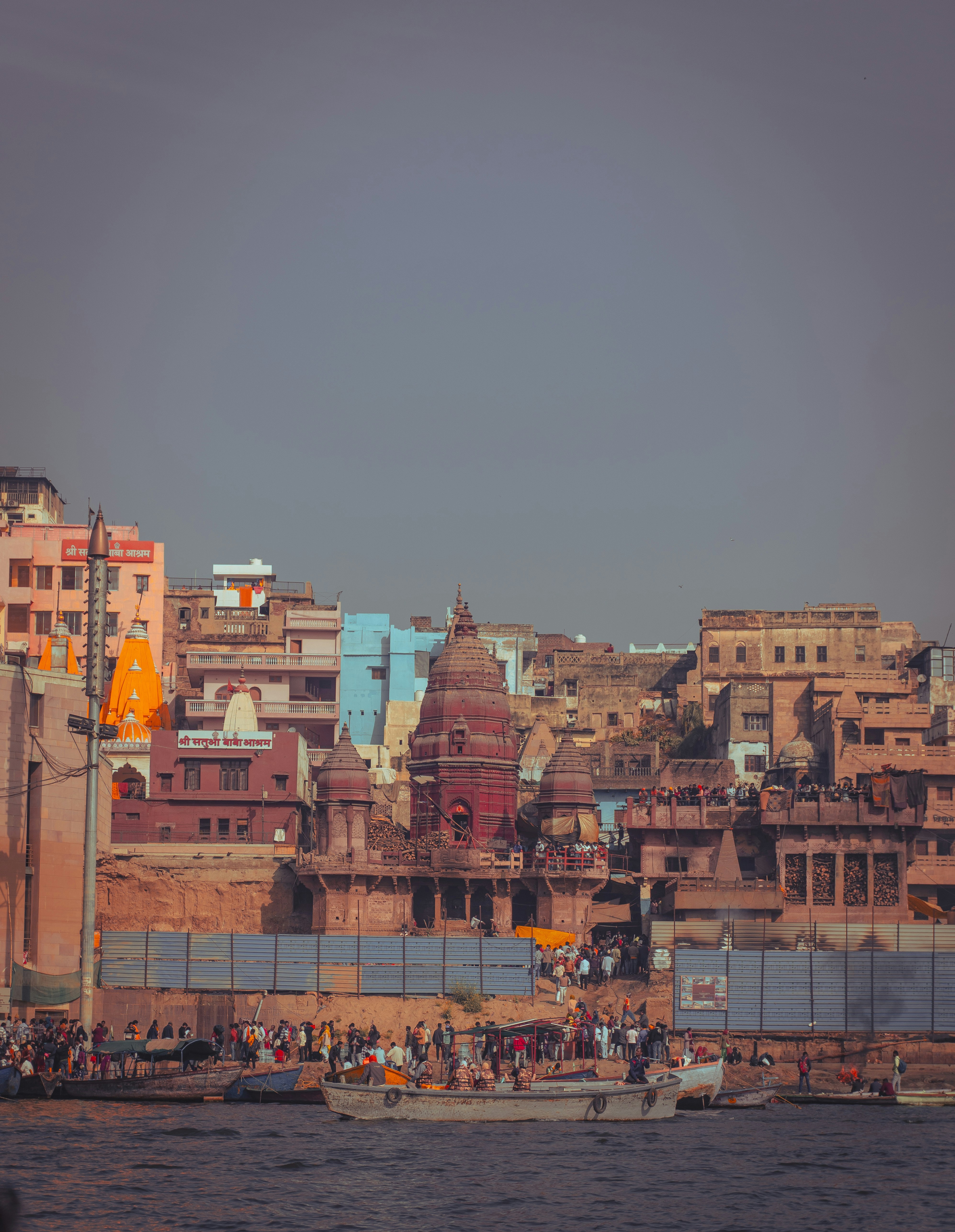 Historic temple juxtaposed against vibrant urban architecture along the river, bustling with life and activity.