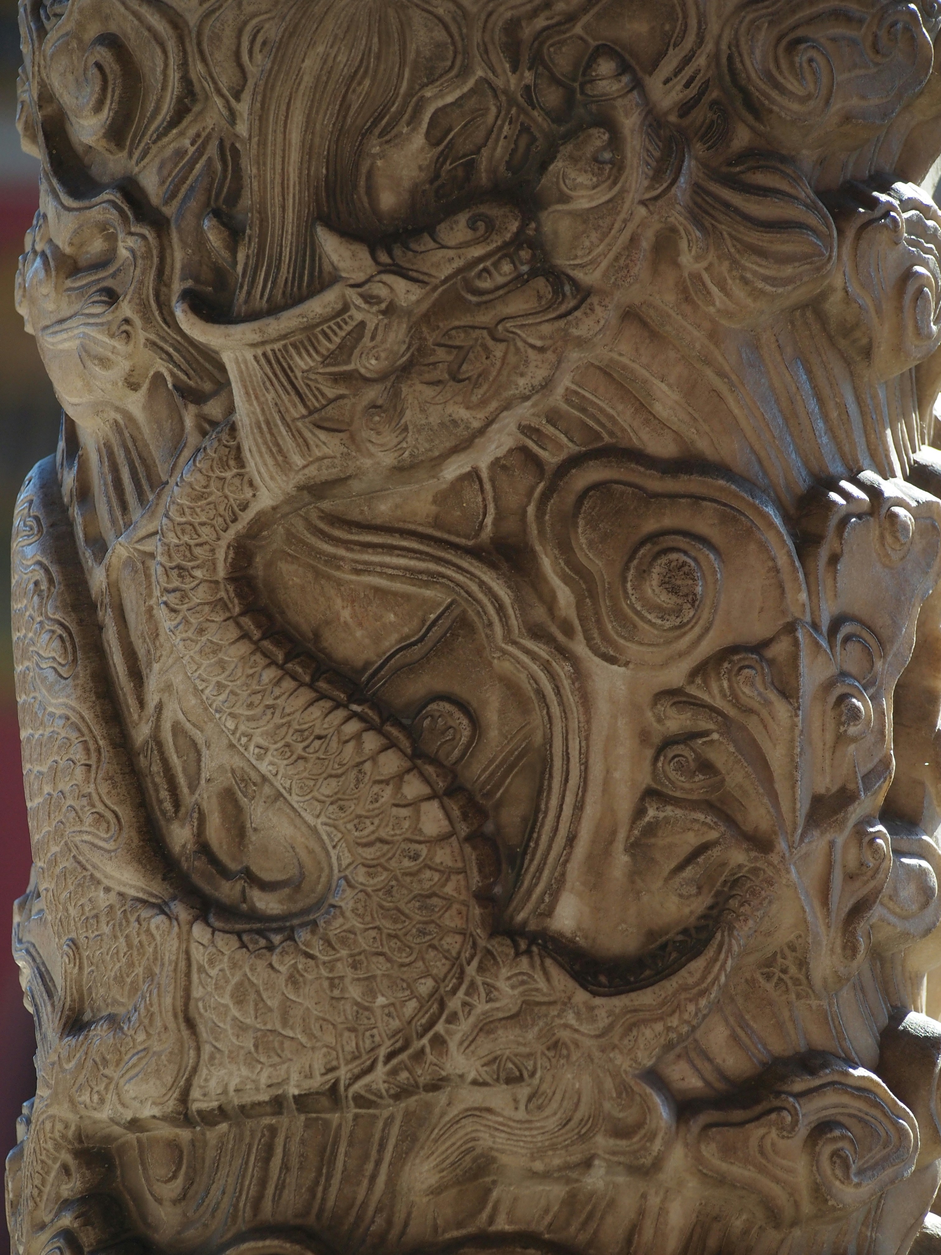 Intricate dragon carving on a stone pillar, showcasing detailed craftsmanship and cultural significance.