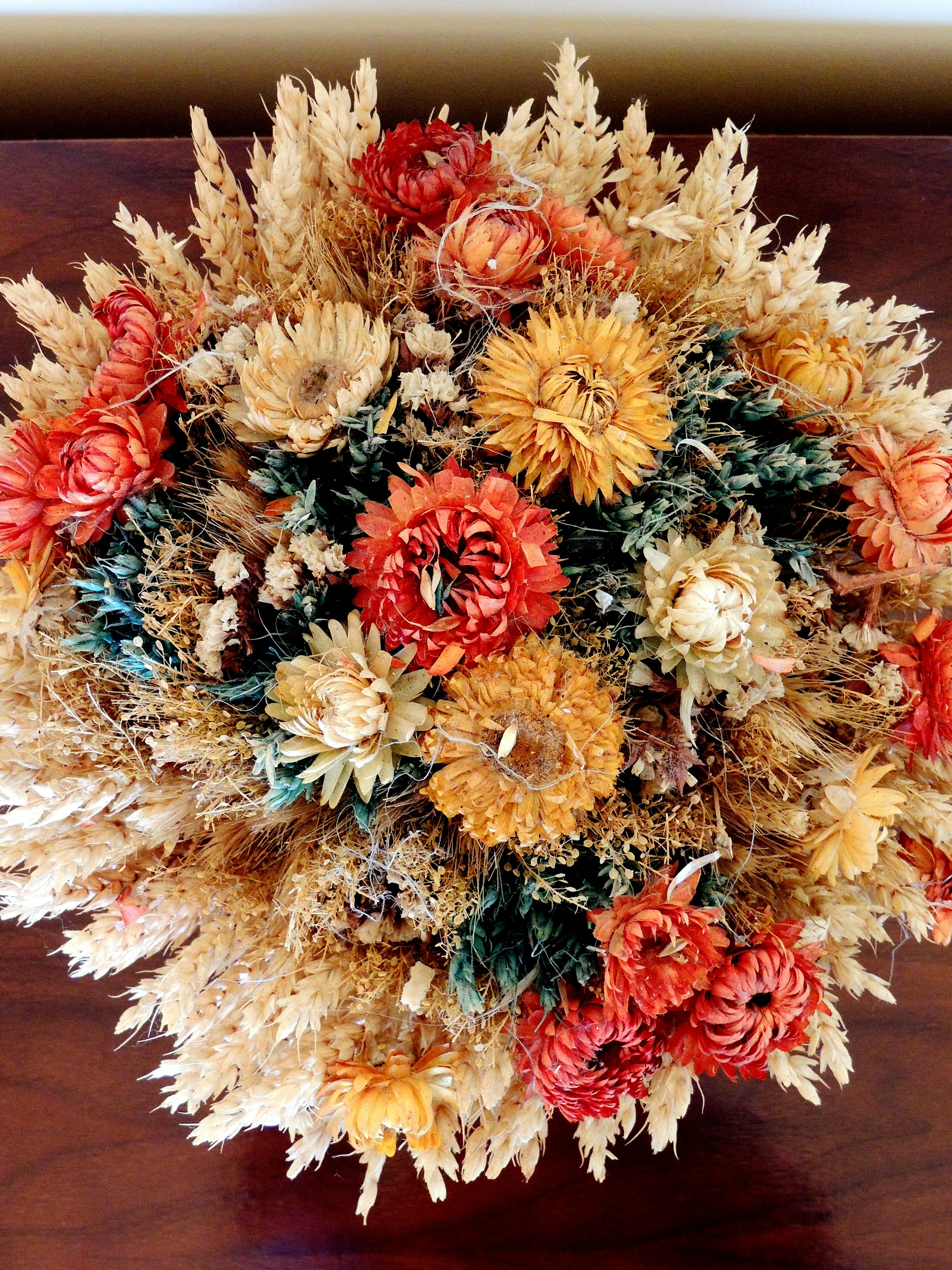 Vibrant arrangement of dried flowers and grasses showcasing a rich array of colors and textures. The composition highlights the beauty of preserved nature.