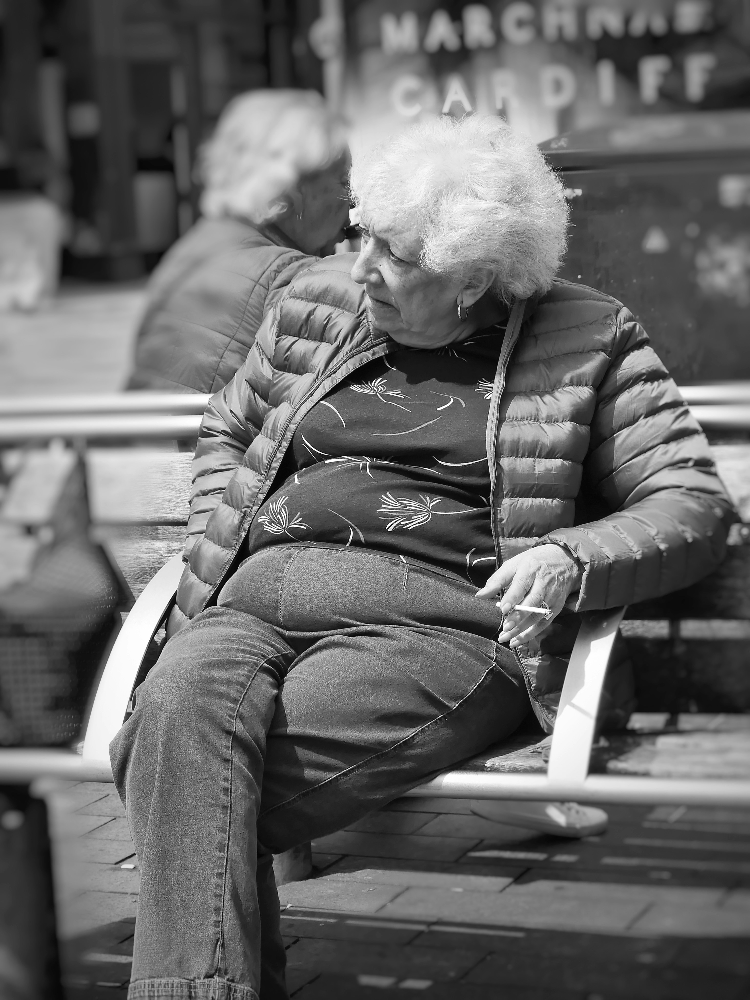 Quiet Dignity on a Park Bench: An Elderly Woman in a Quilted Jacket