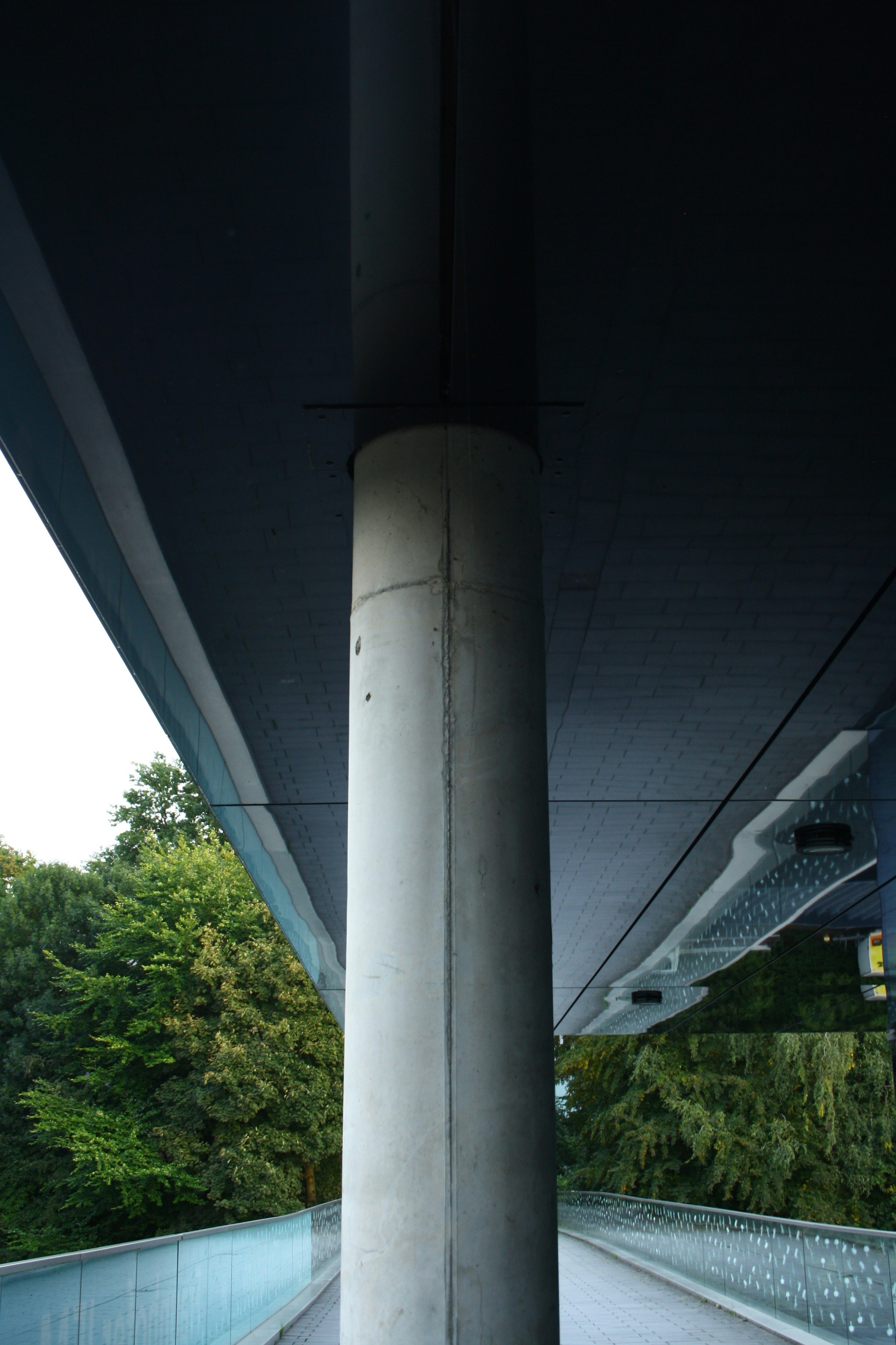 Underbridge Pillar: A Quiet Corridor Framed by Steel and Trees