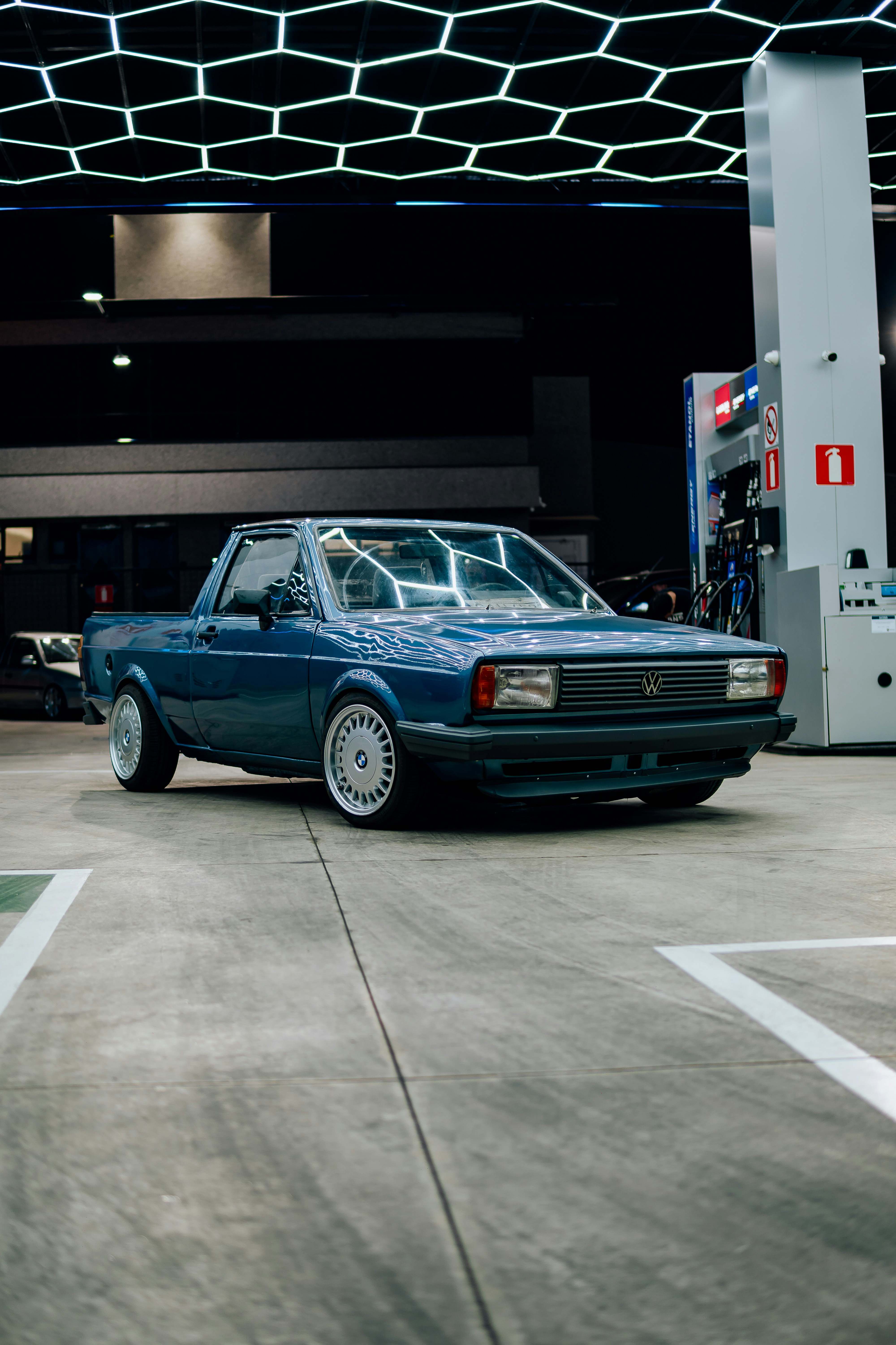 Neon-Grid Night: A Classic Volkswagen Pickup in a Modern Showroom