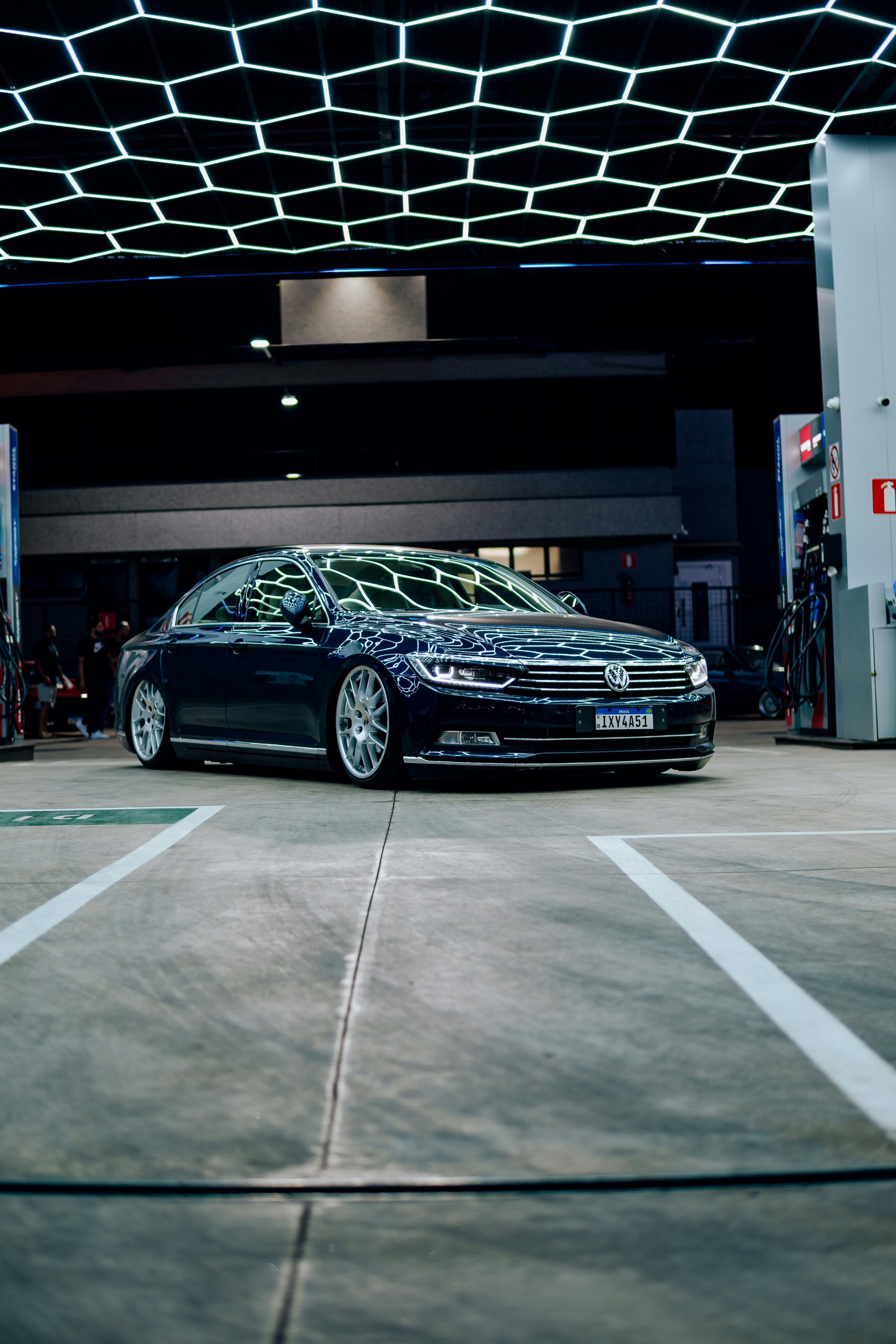Hex Grid Neon Showroom: VW Sedan in Quiet Illumination