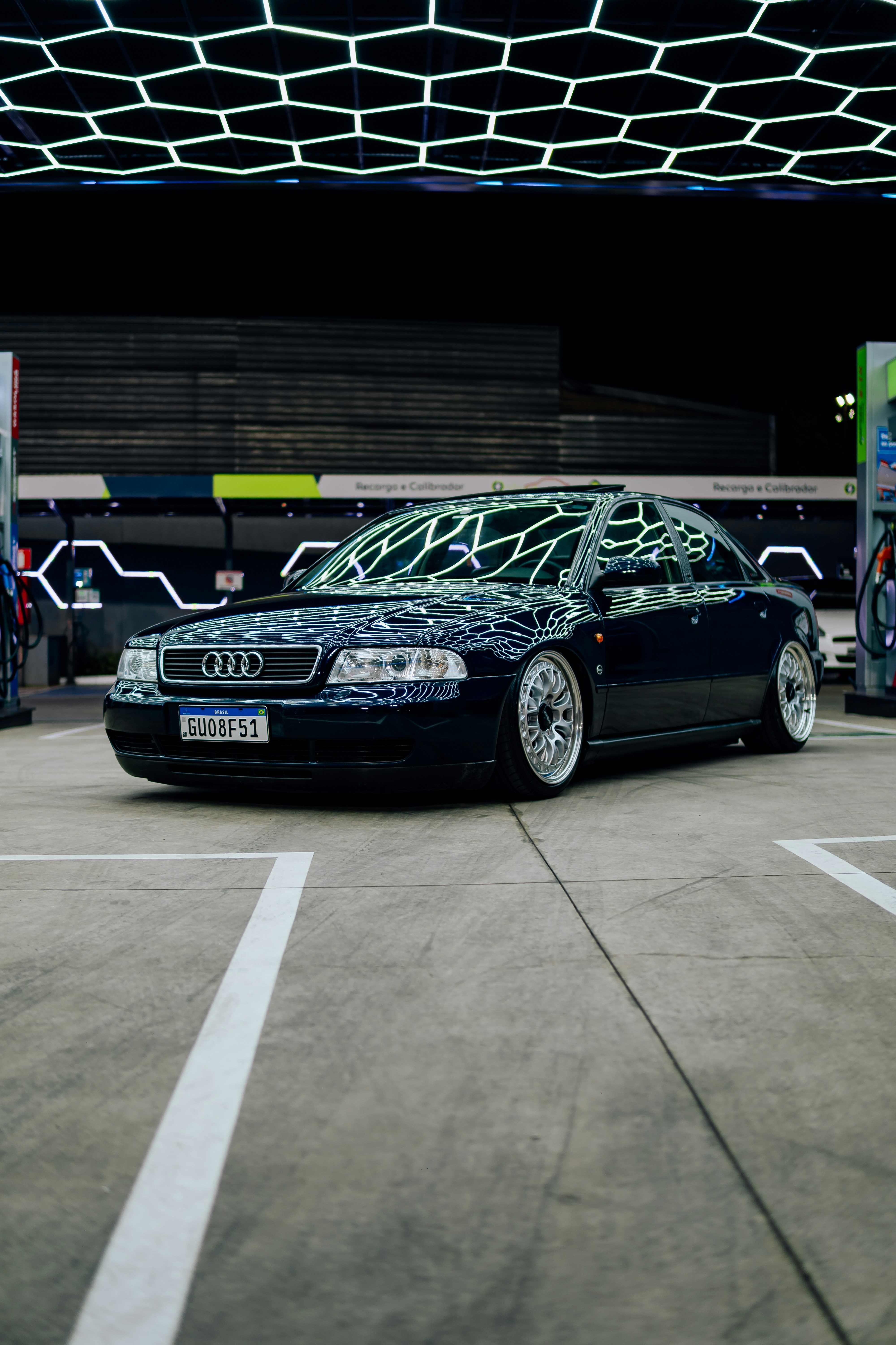 Hex-lit Reflections: A Midnight Audi Under a Neon Canopy