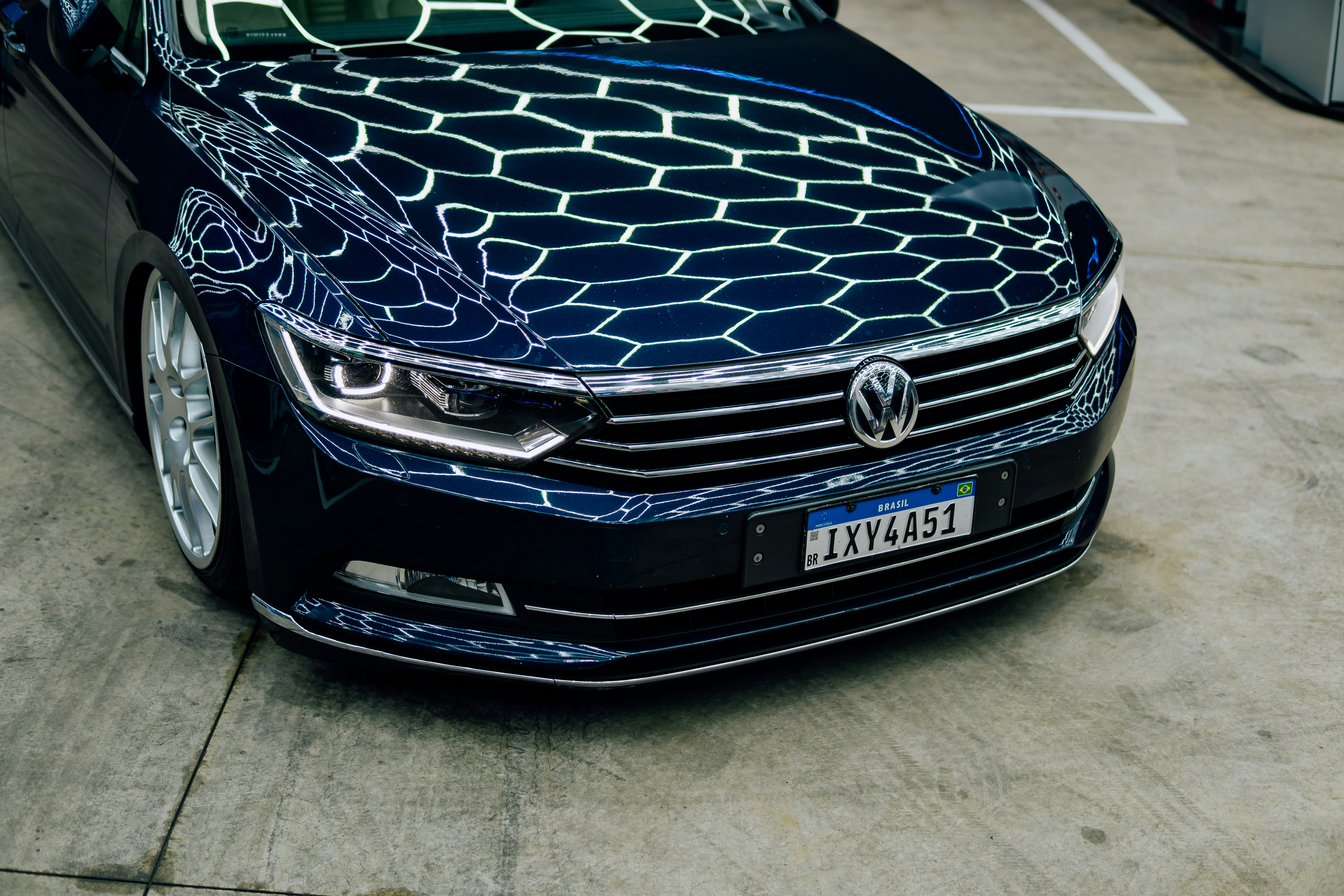 Hex-Pattern Reflections Cascade Across a Deep-Blue VW Front