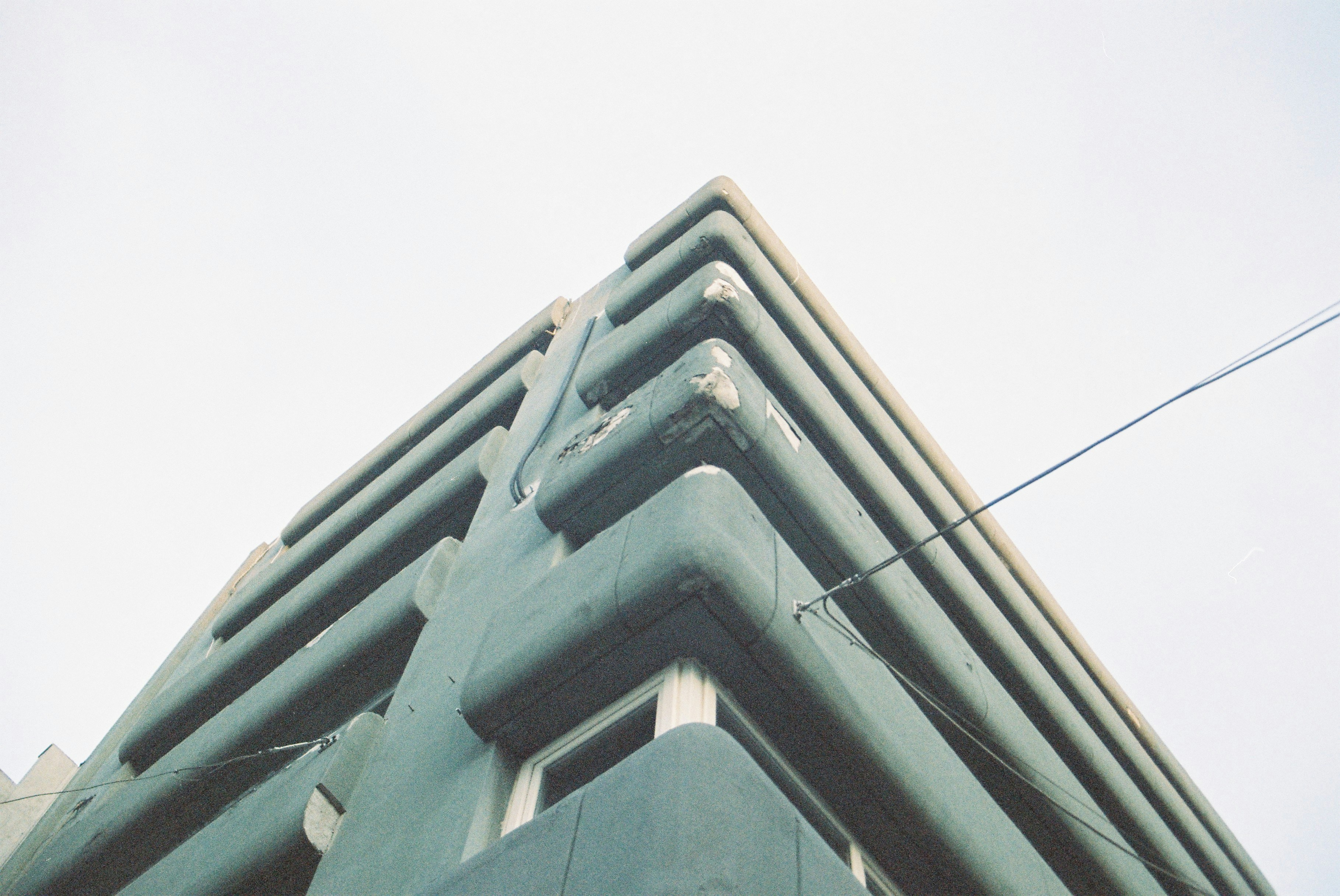 Diagonal Edge: A Teal Facade Reaches for the Sky