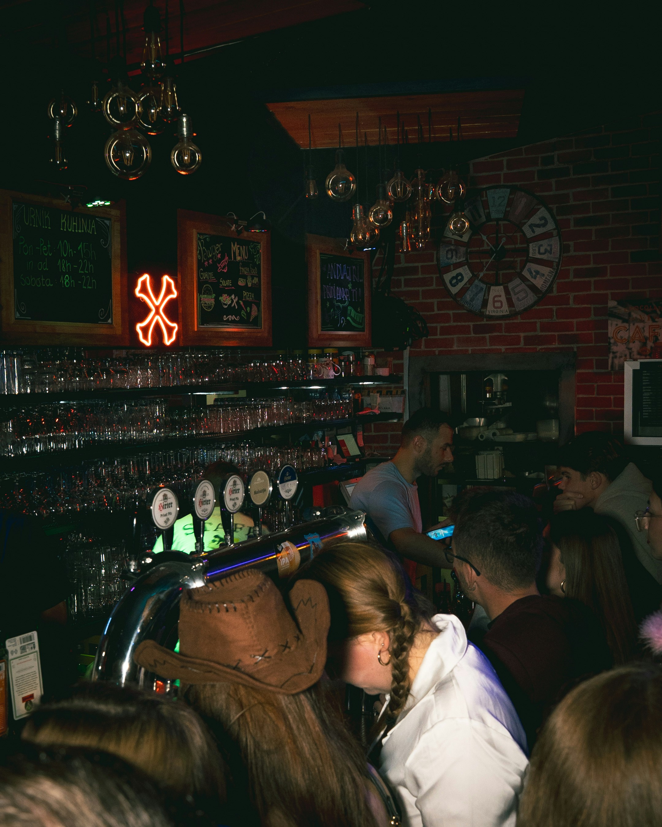 Neon X Over a Crowded Night Bar