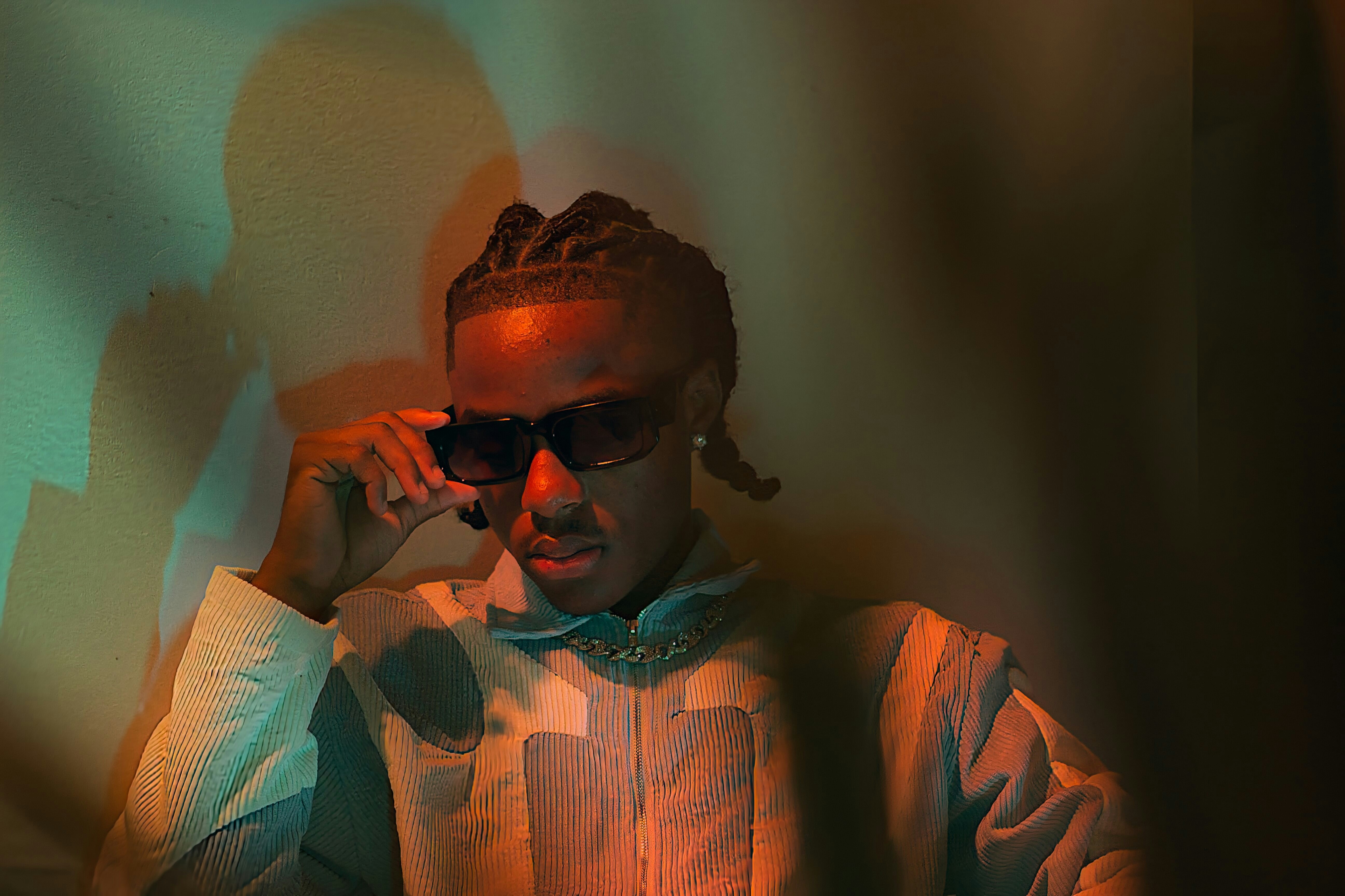 Even in the shadows, style speaks louder than words. A laid-back moment of reflection framed in warm and cool light.