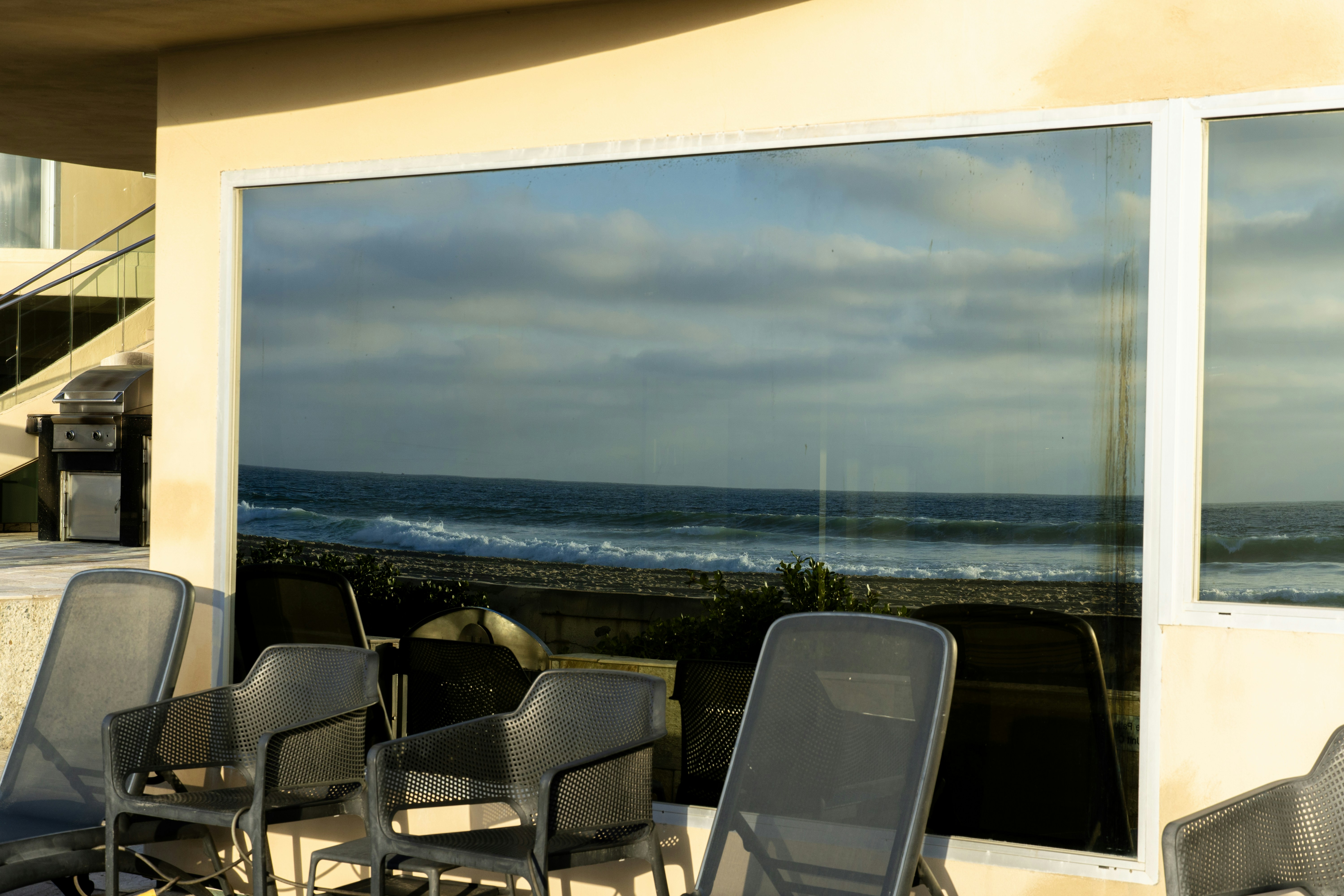 Glass-Horizon Patio: Empty Chairs by the Sea