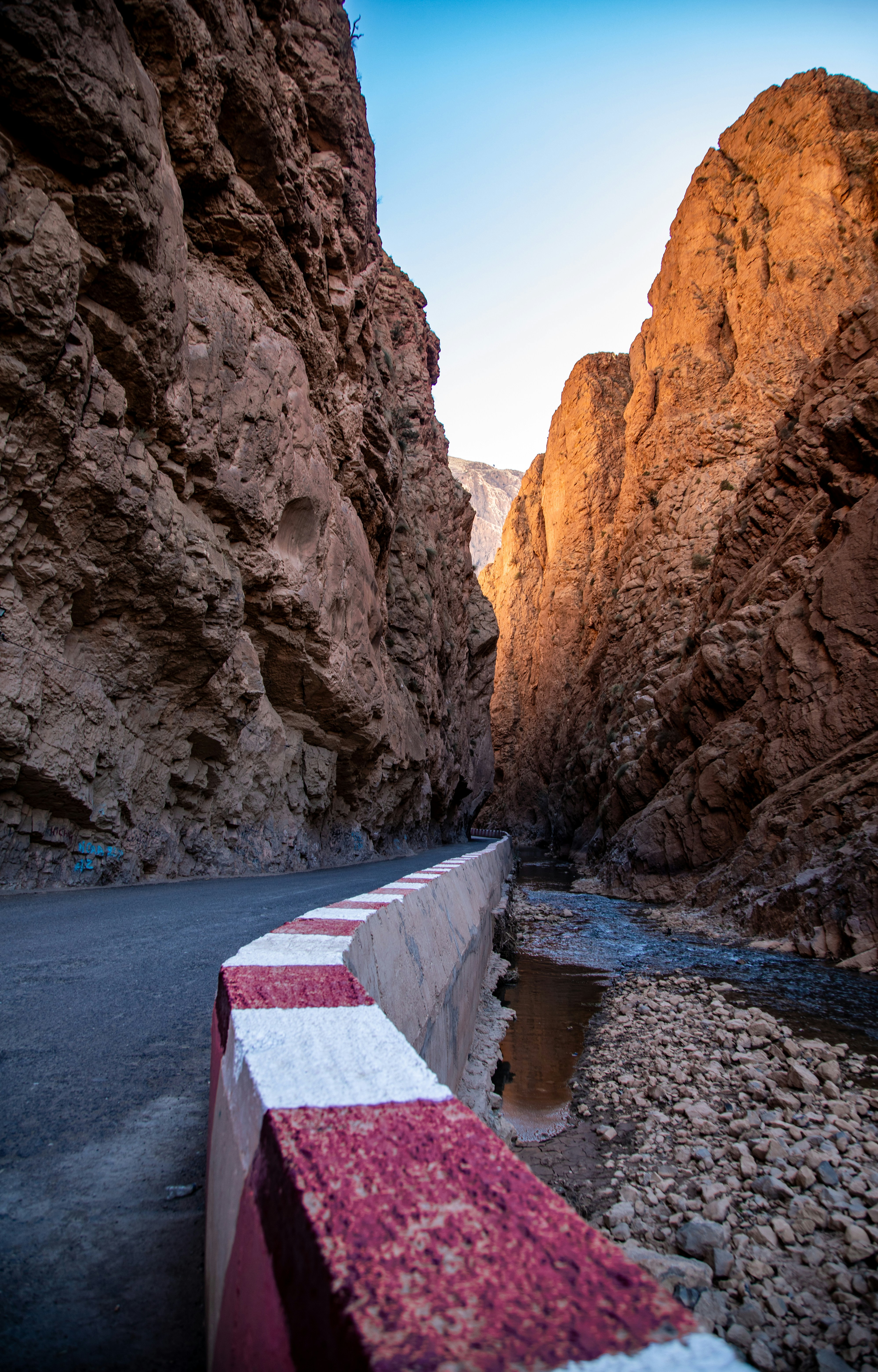 Cerulean Sky over a Red-Walled Gorge: A Narrow Road Between Giants