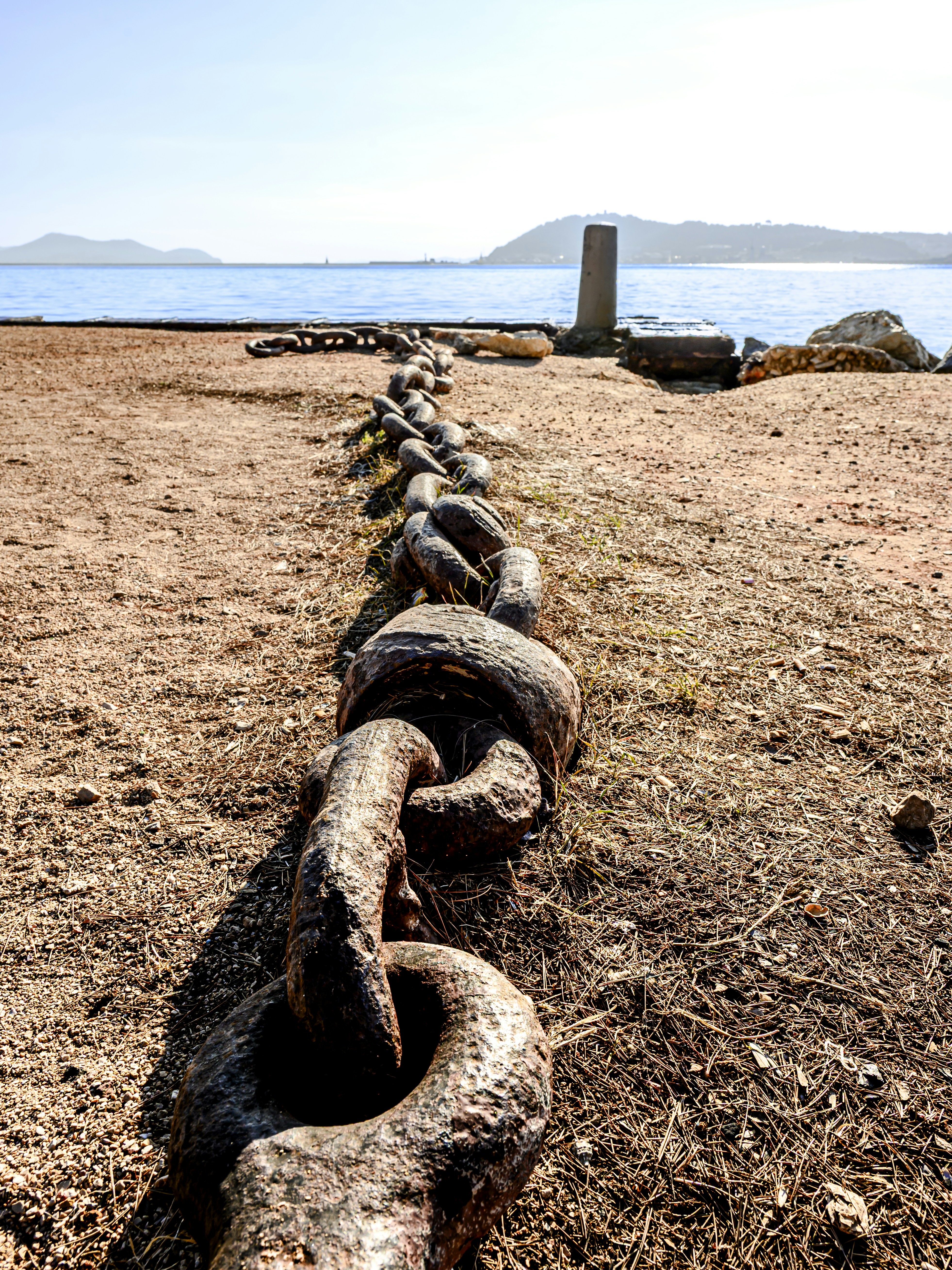 Iron Thread to the Sea: A Shoreline Chain Leads the Eye Toward Quiet Horizons