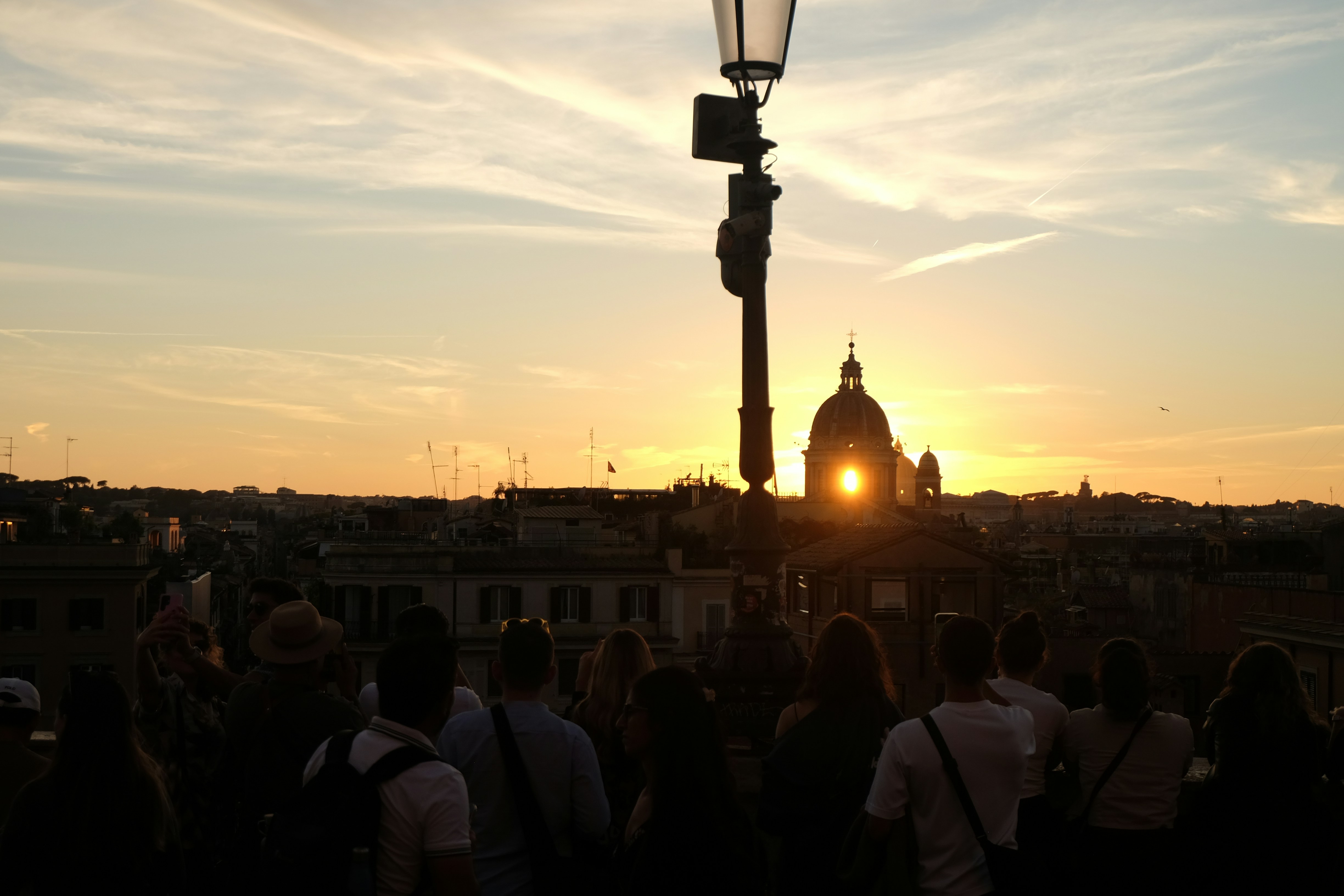 Sunset over a city skyline with a dome.
