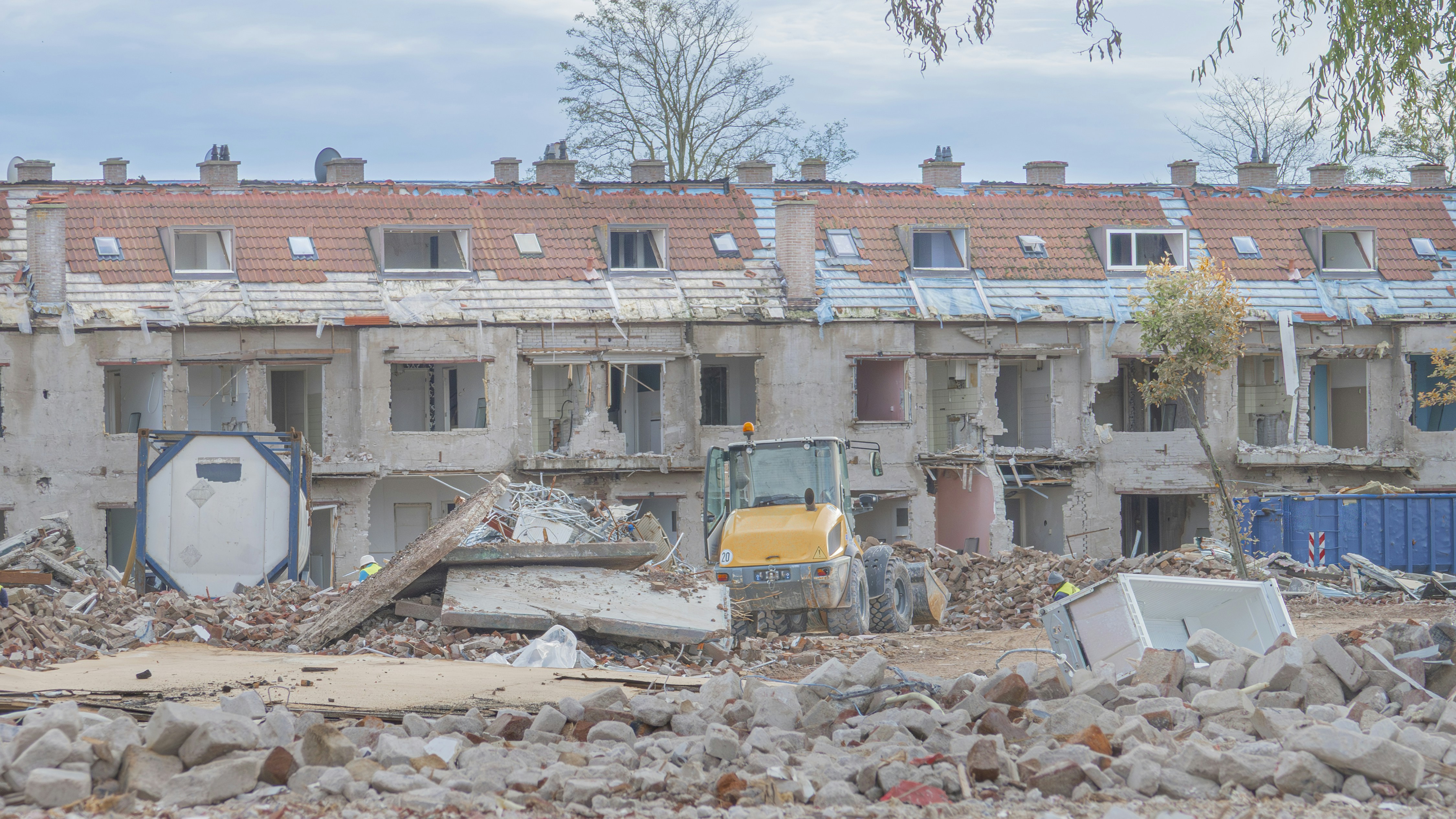 Construction machinery amidst the rubble of a demolished building, revealing the remnants of past structures and the transition to new developments.