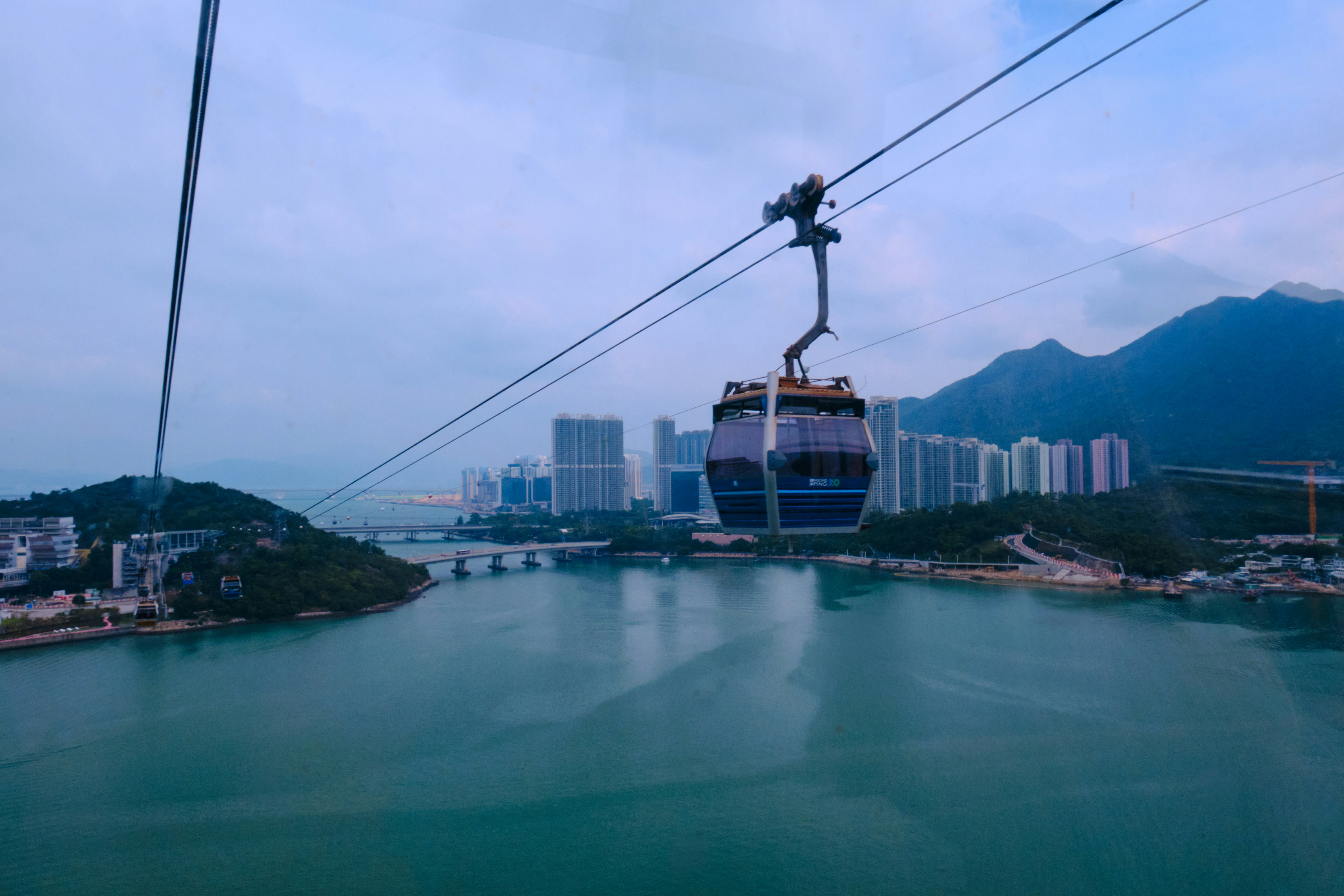Gondola Glide Over Turquoise Harbor Toward the City's Ridge
