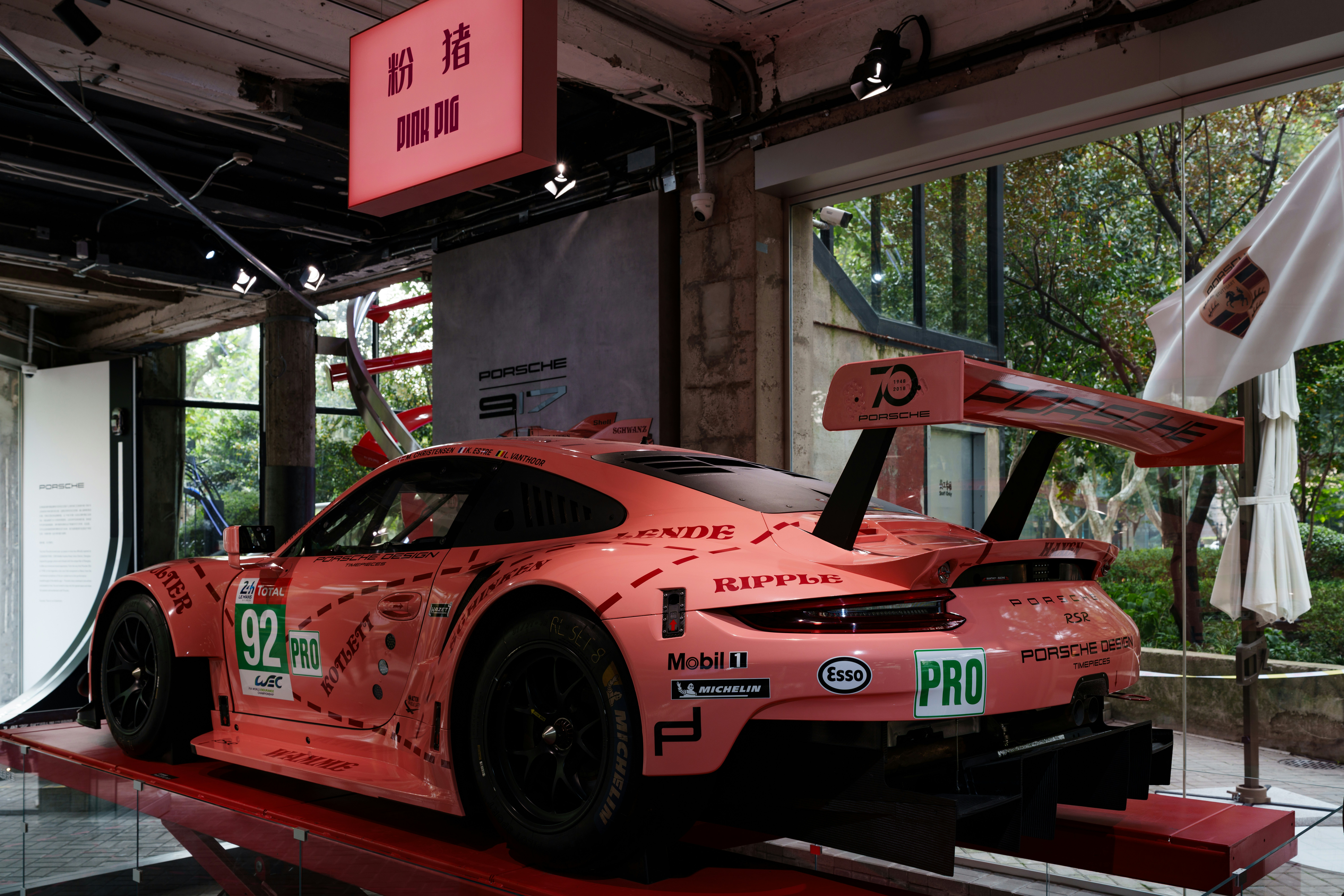 A pink racing car with sponsor logos on display.