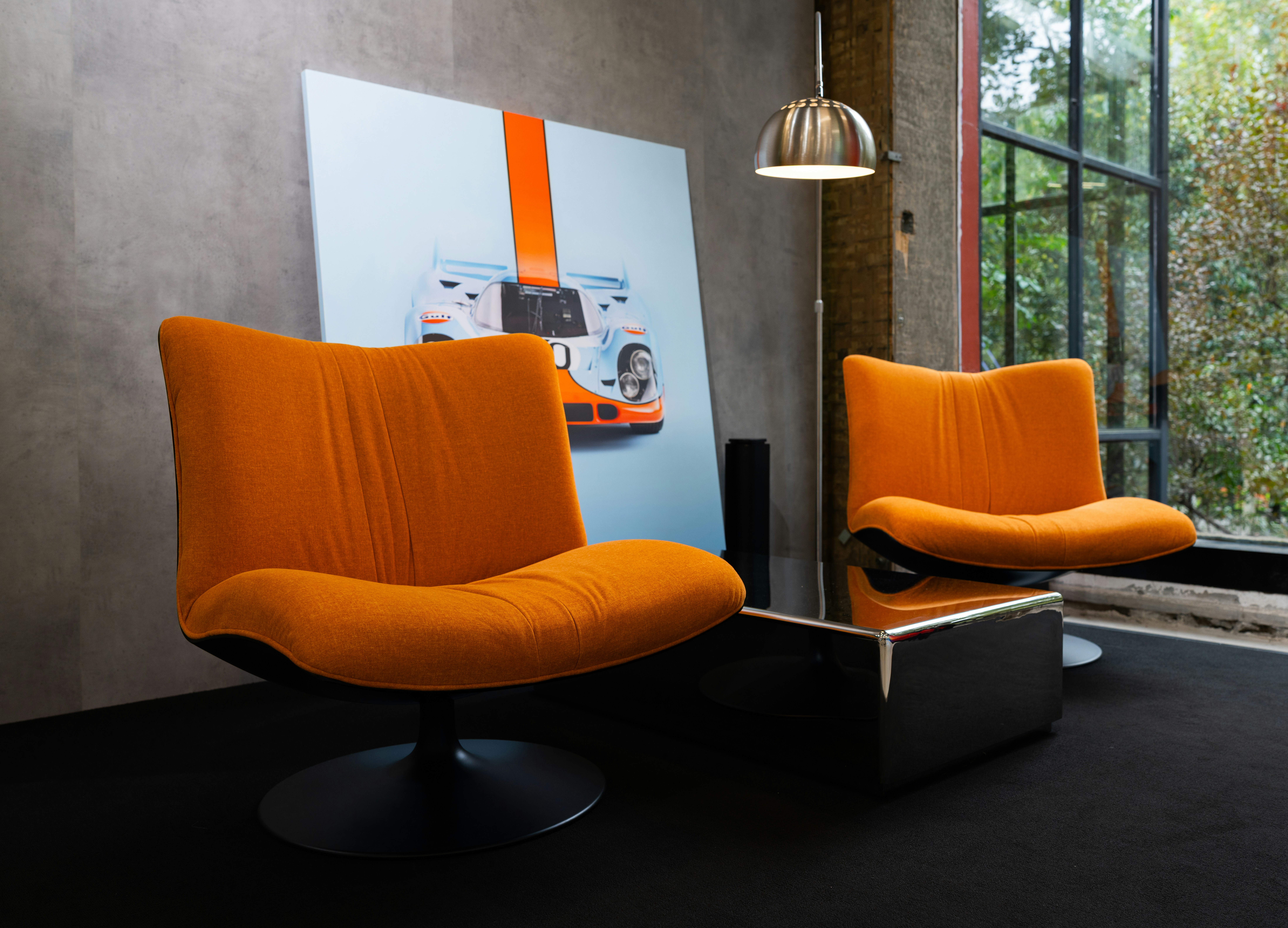 Amber Lounge Duo: Orange Seats in an Industrial Gallery with Car-Themed Artwork