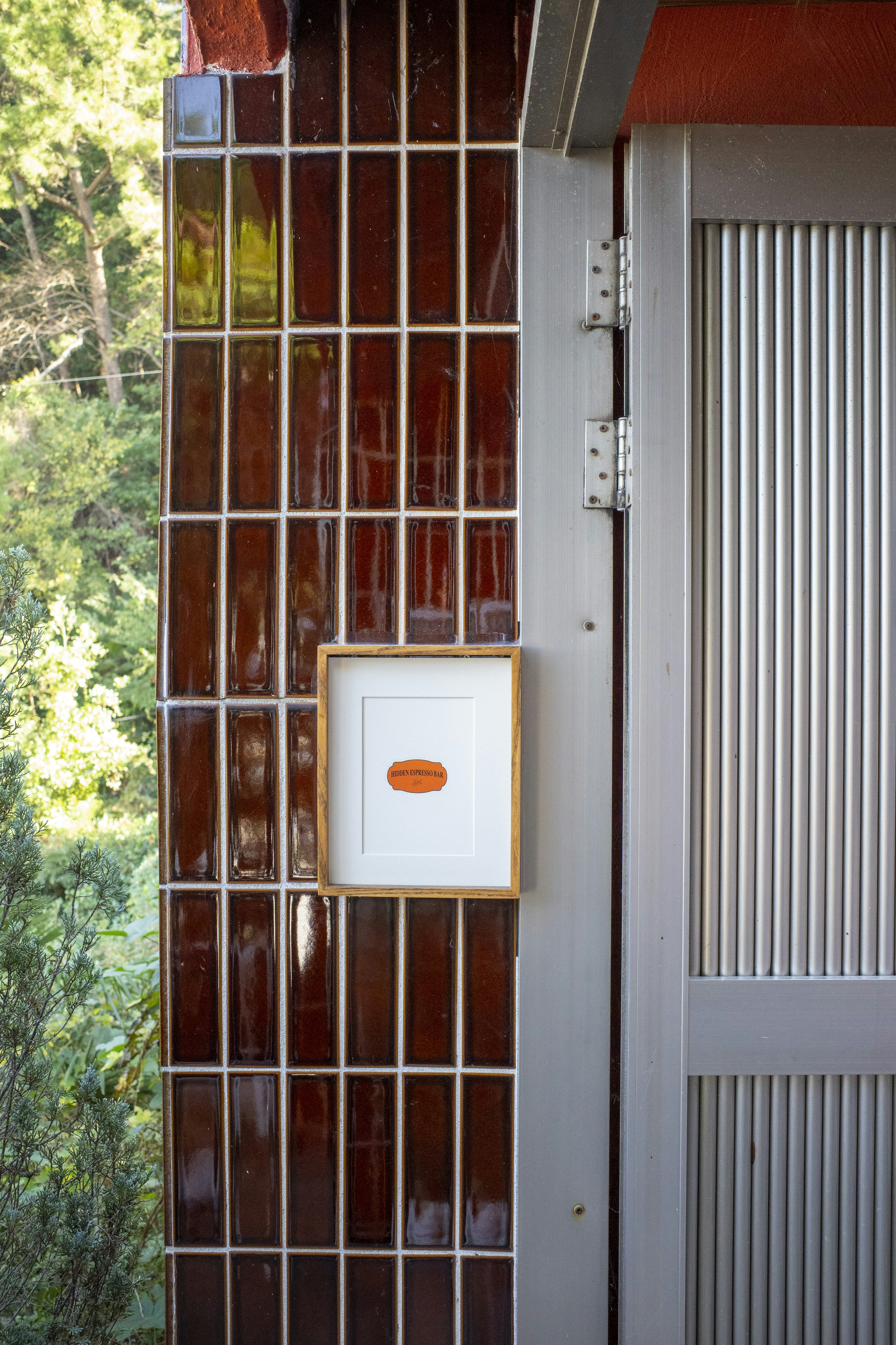 Orange Label Framed on a Burgundy Tile Wall