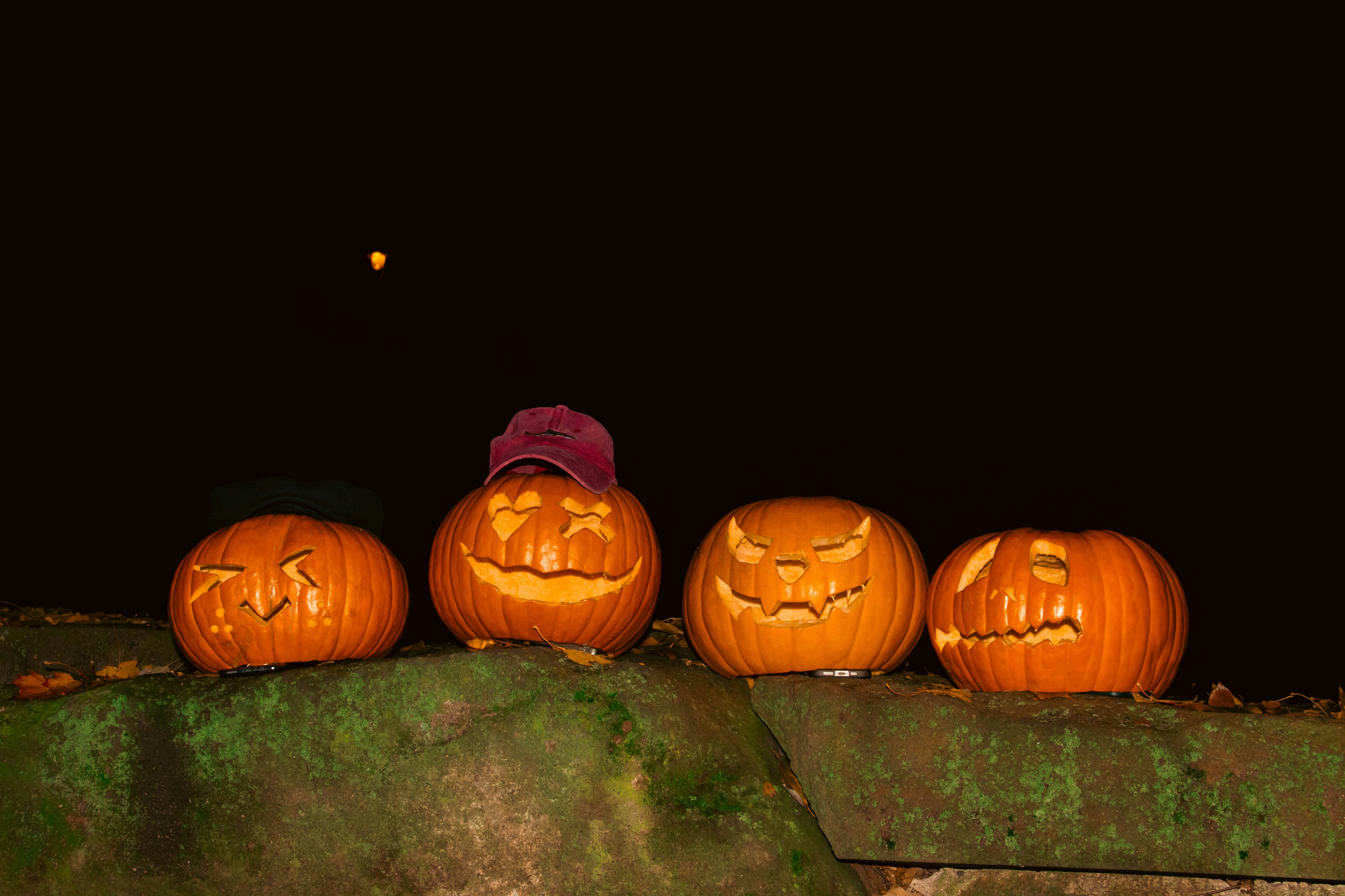 Midnight Row of Glowing Jack-o’-Lanterns on Mossy Stone