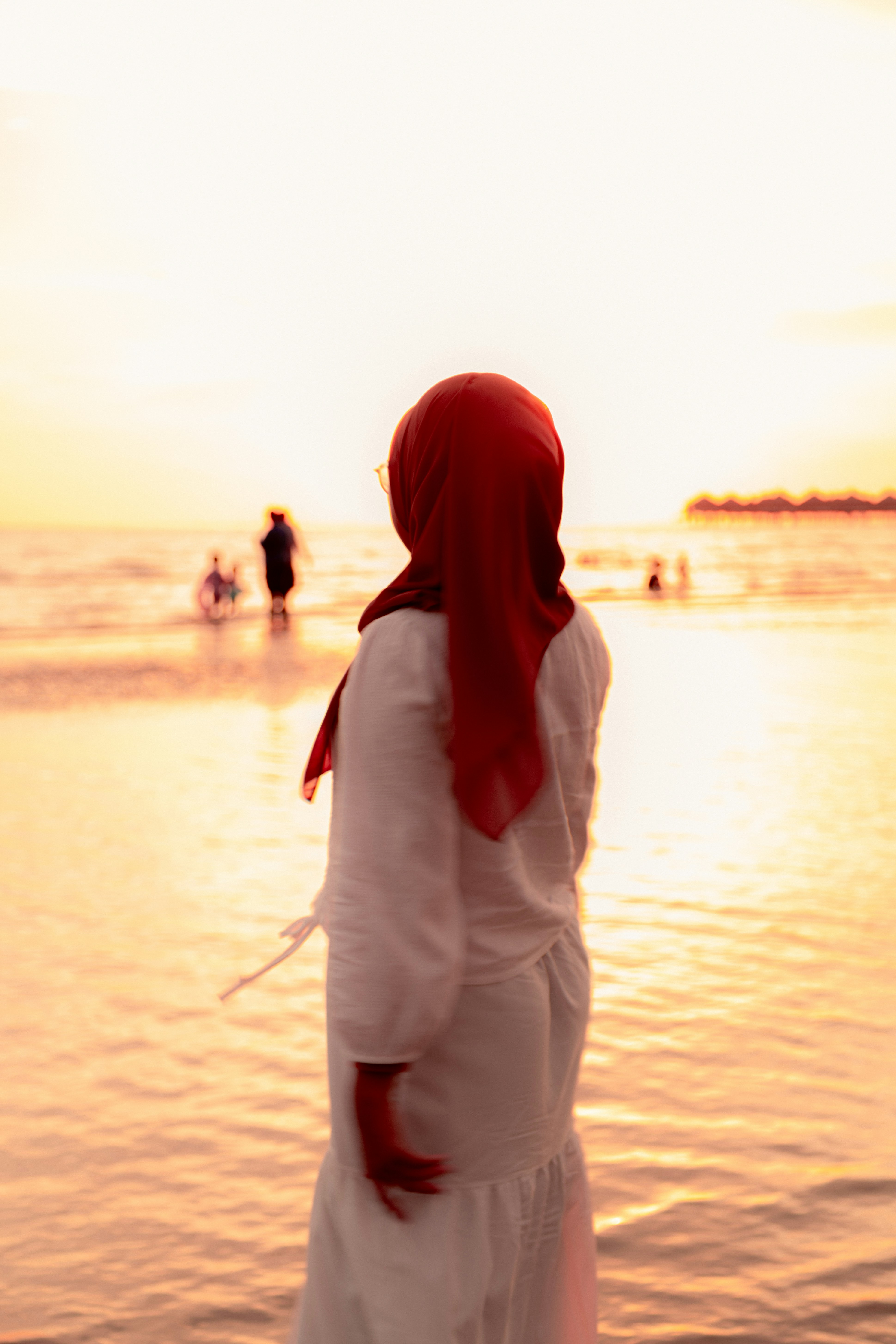 Red Hijab at Dusk: A Solitary Silhouette on the Sunset Beach