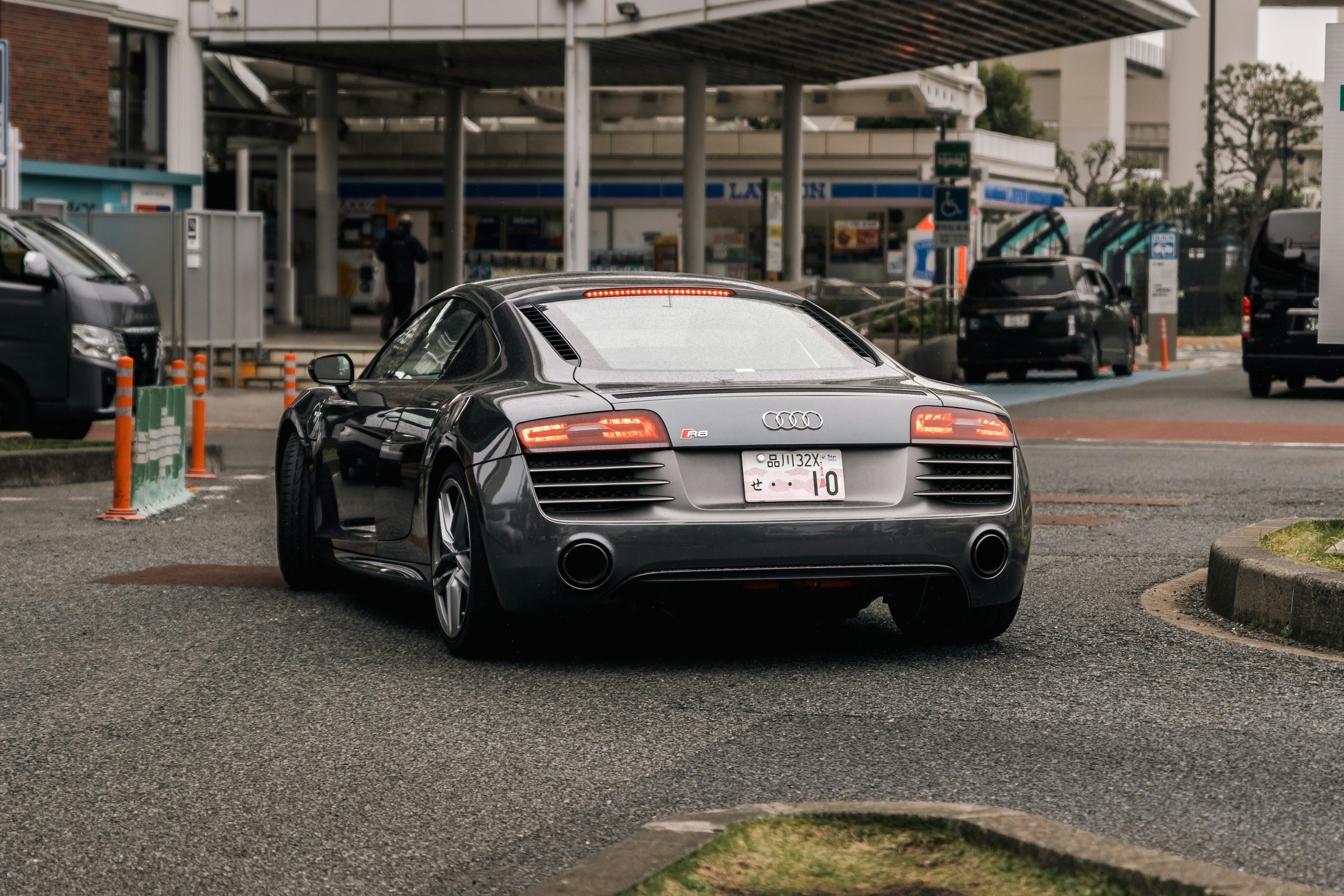 Audi R8 sports car gracefully navigating a modern urban environment, showcasing its sleek design and dynamic presence.