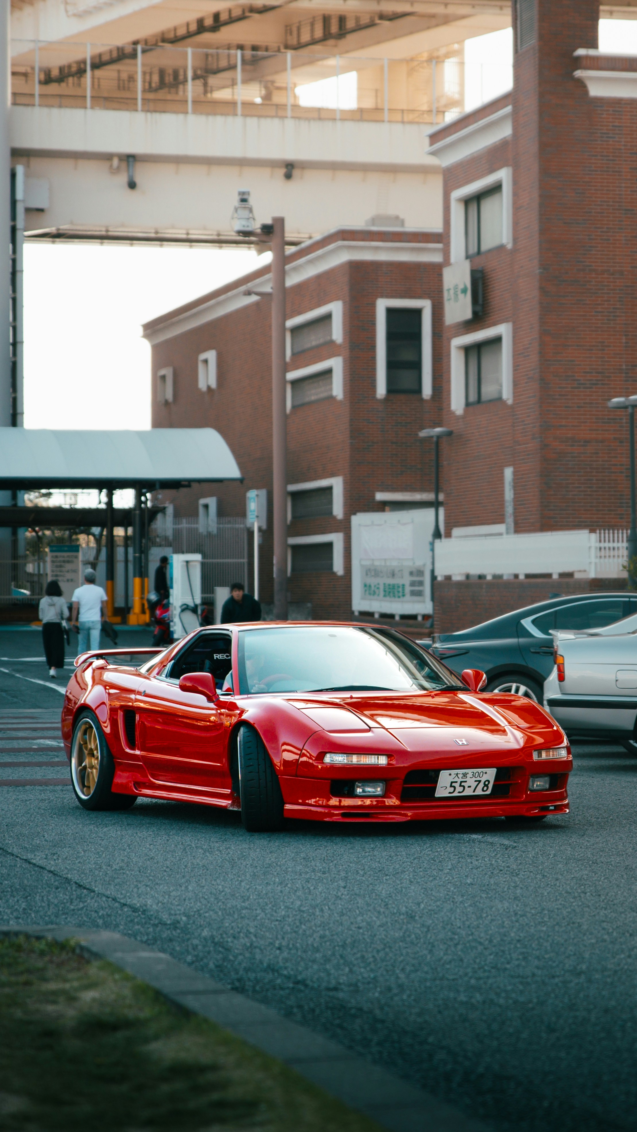 Crimson Mirage: A Red Exotic Car Rides Through an Industrial City Backdrop