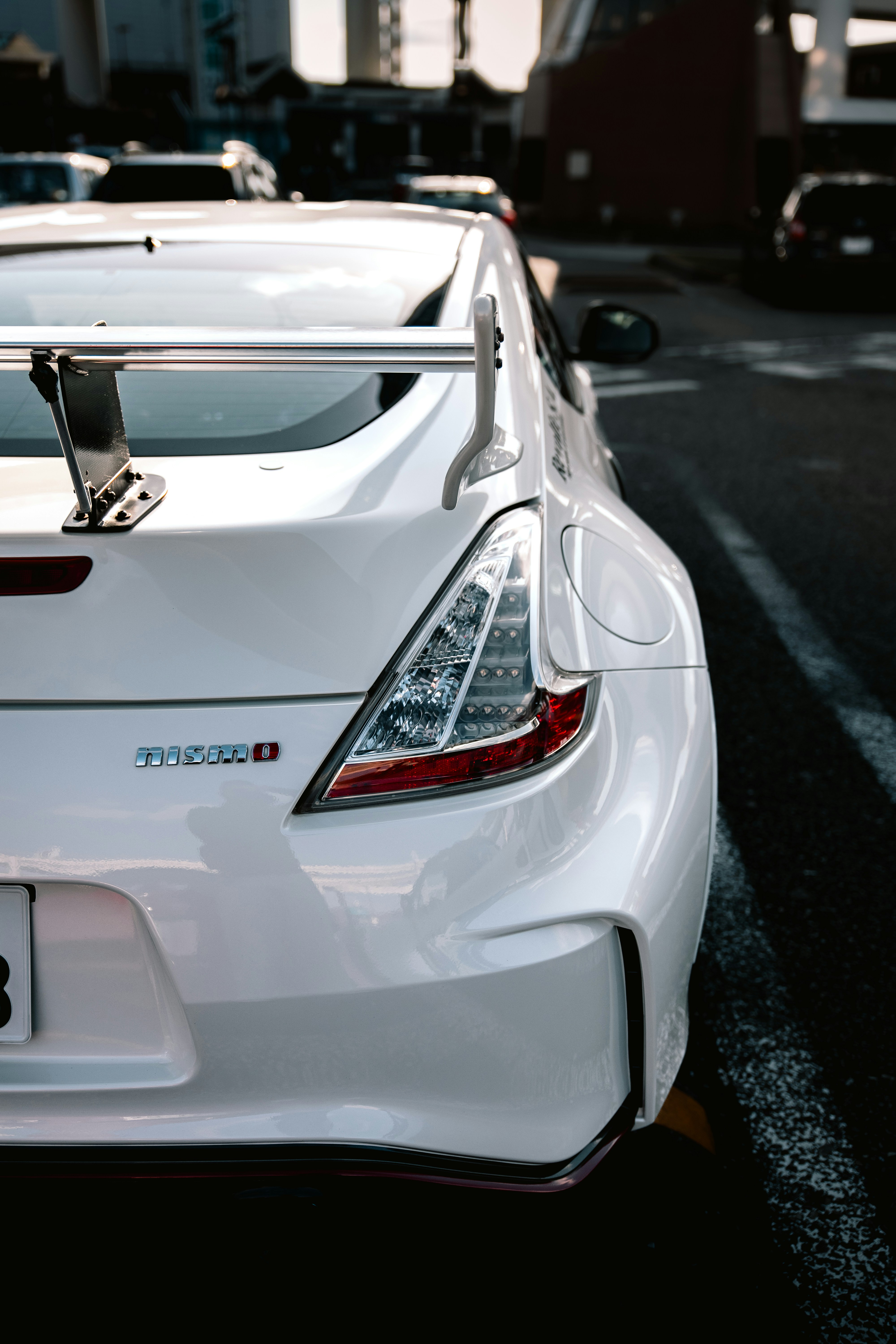 Rear Wing, White Nissan Z: Chrome Accents and Urban Backdrop