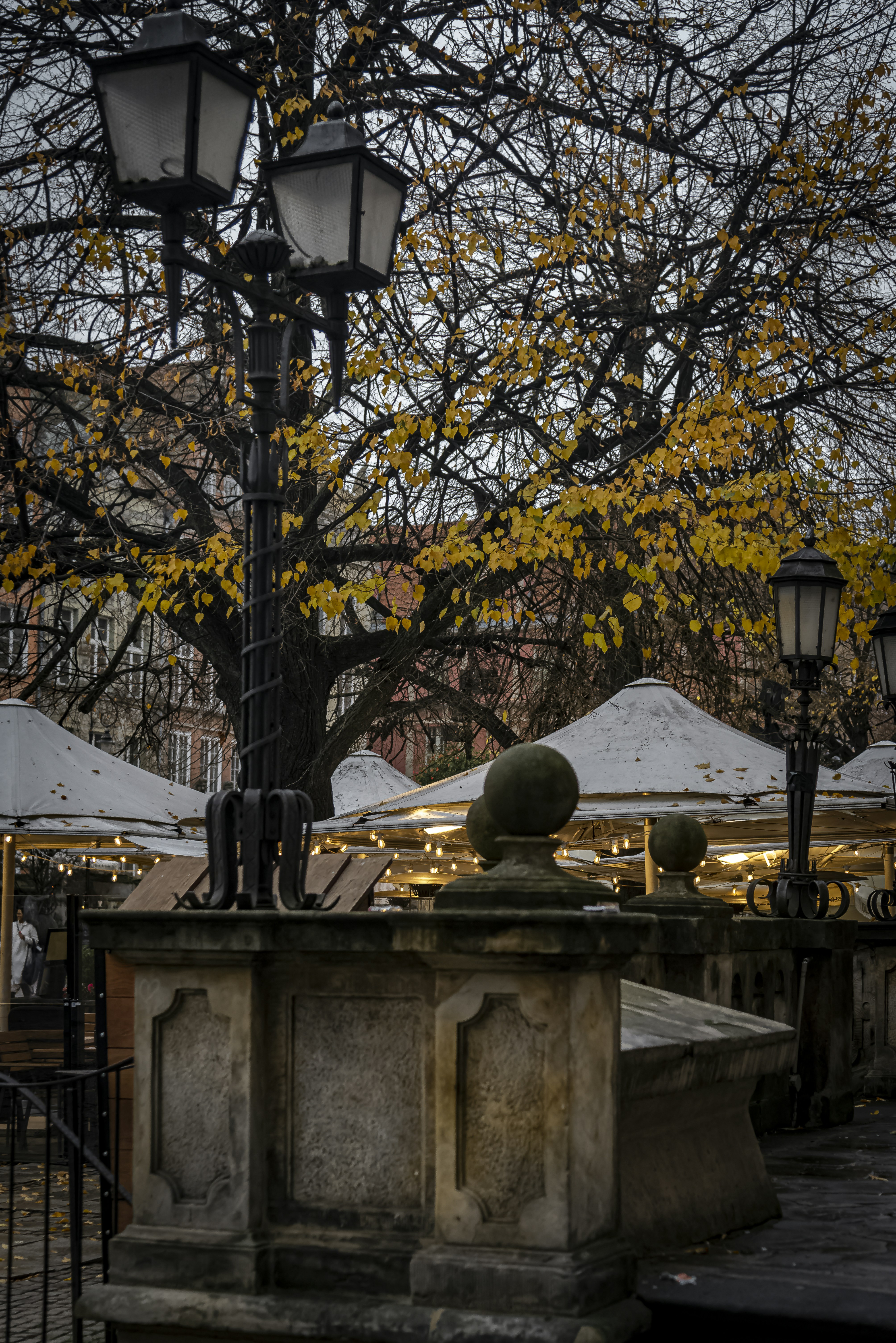 Overcast Autumn Lanterns Over a Quiet European Square