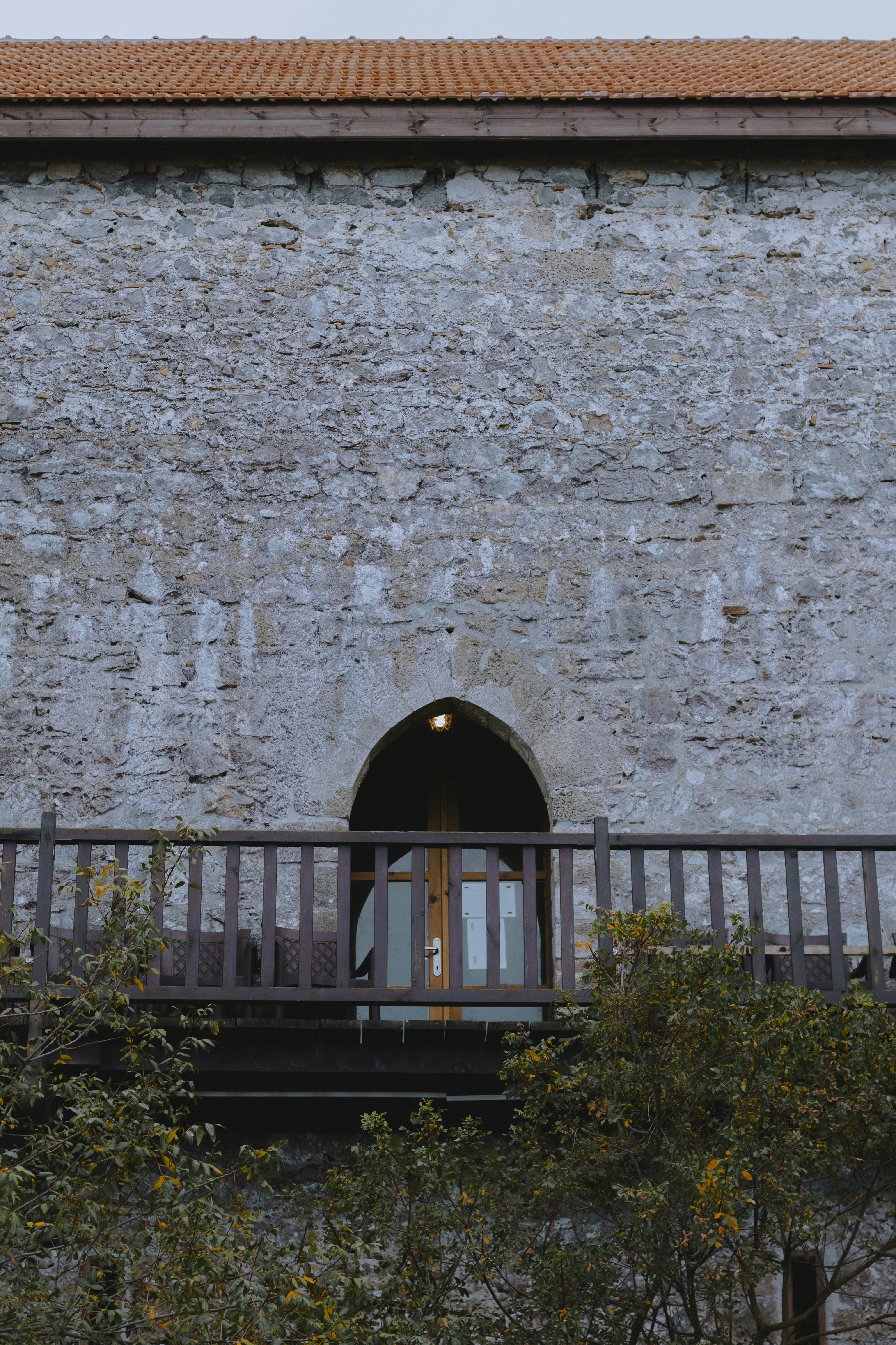 Archway at the Edge: Weathered Stone and a Quiet Balcony
