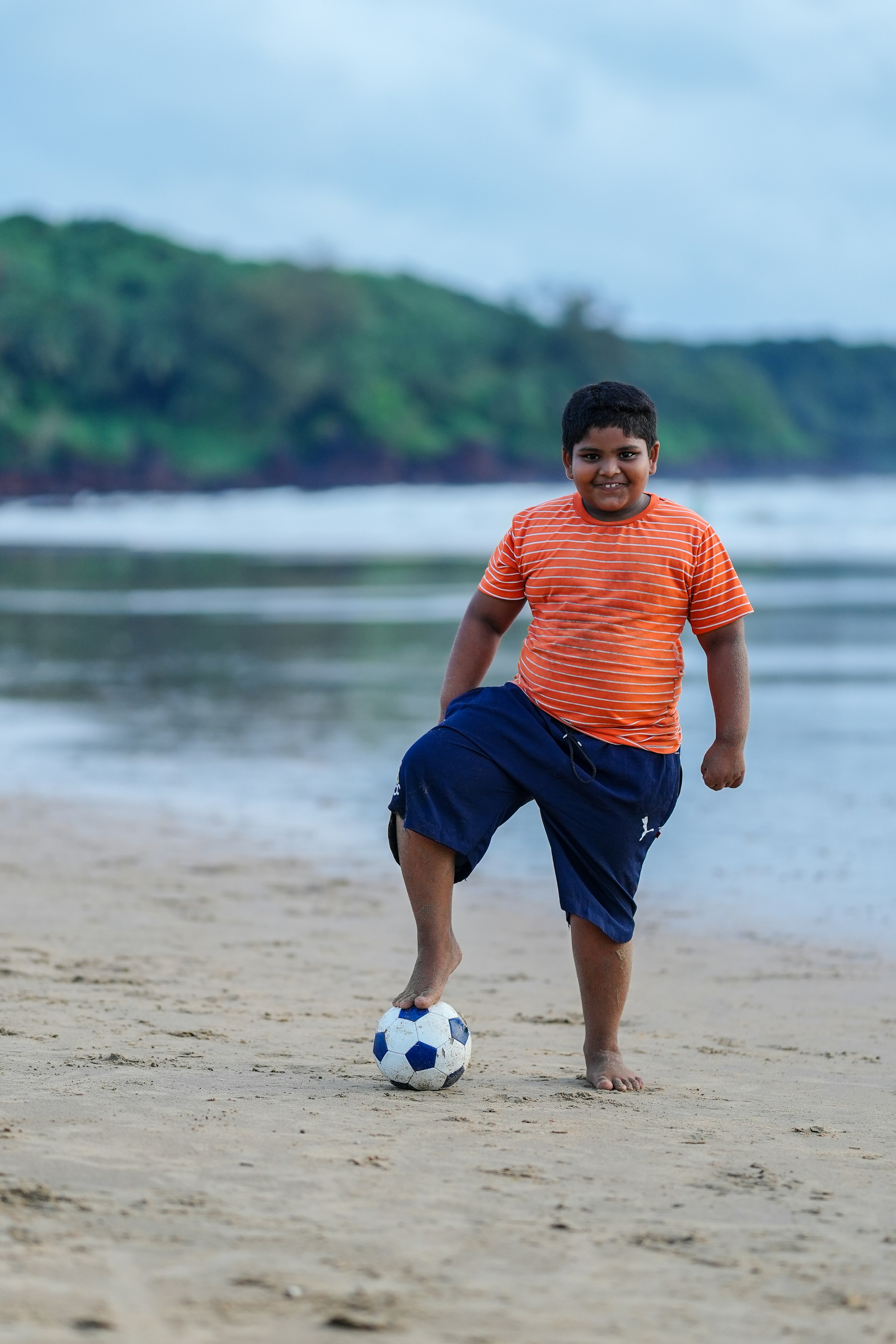 Beachside Kick: A Boy Balances with a Soccer Ball