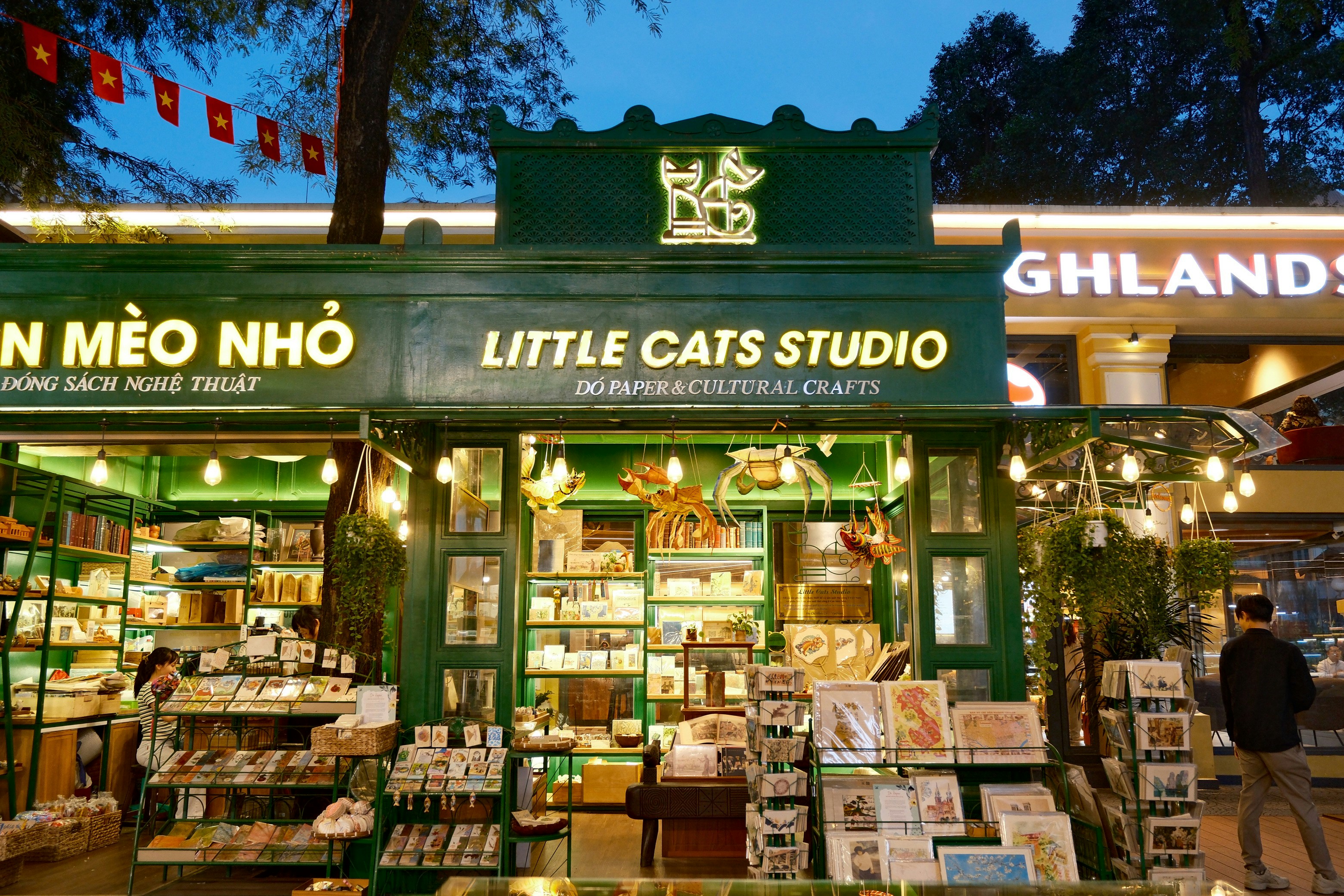 Green storefront for little cats studio with merchandise inside.