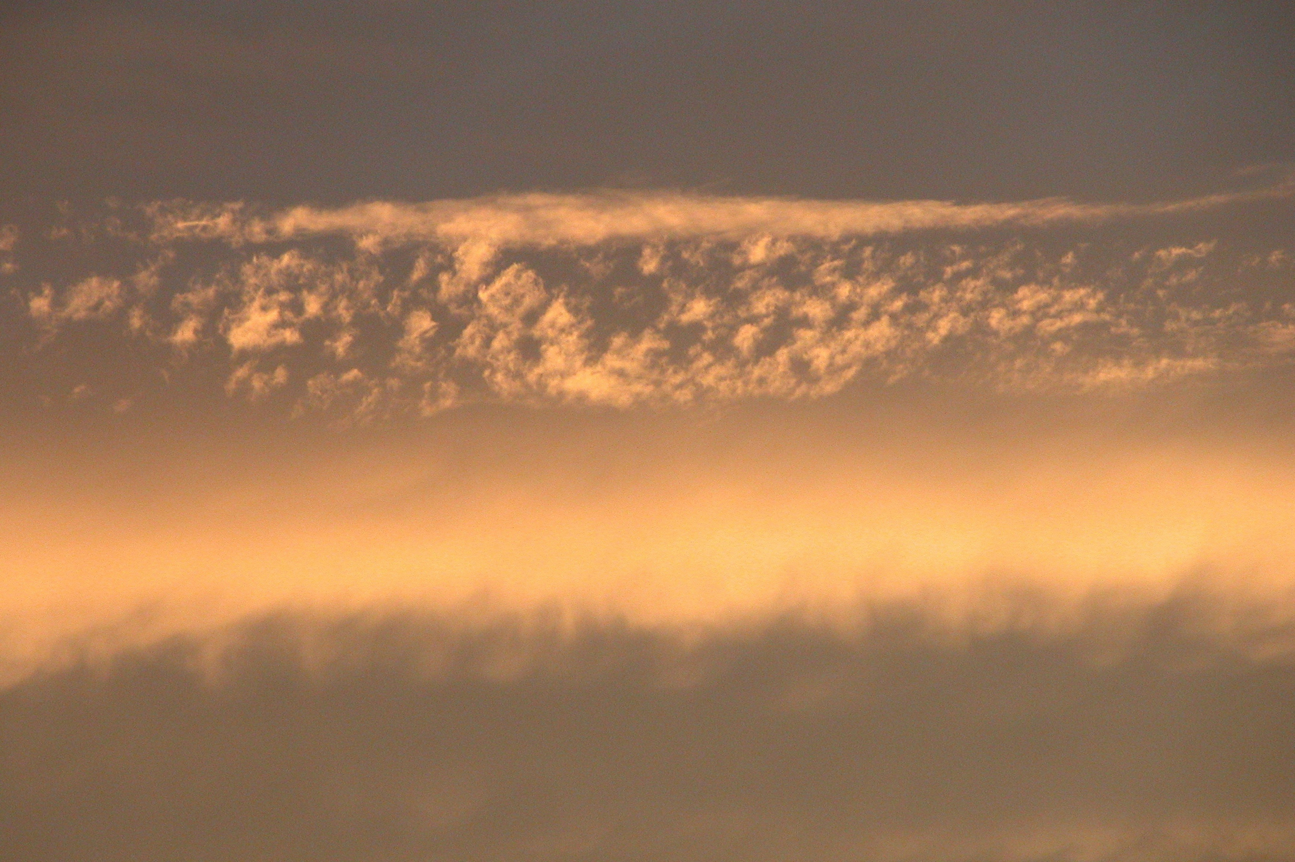 Golden Ridge at Dusk: A Narrow Cloud Band Over a Quiet Horizon