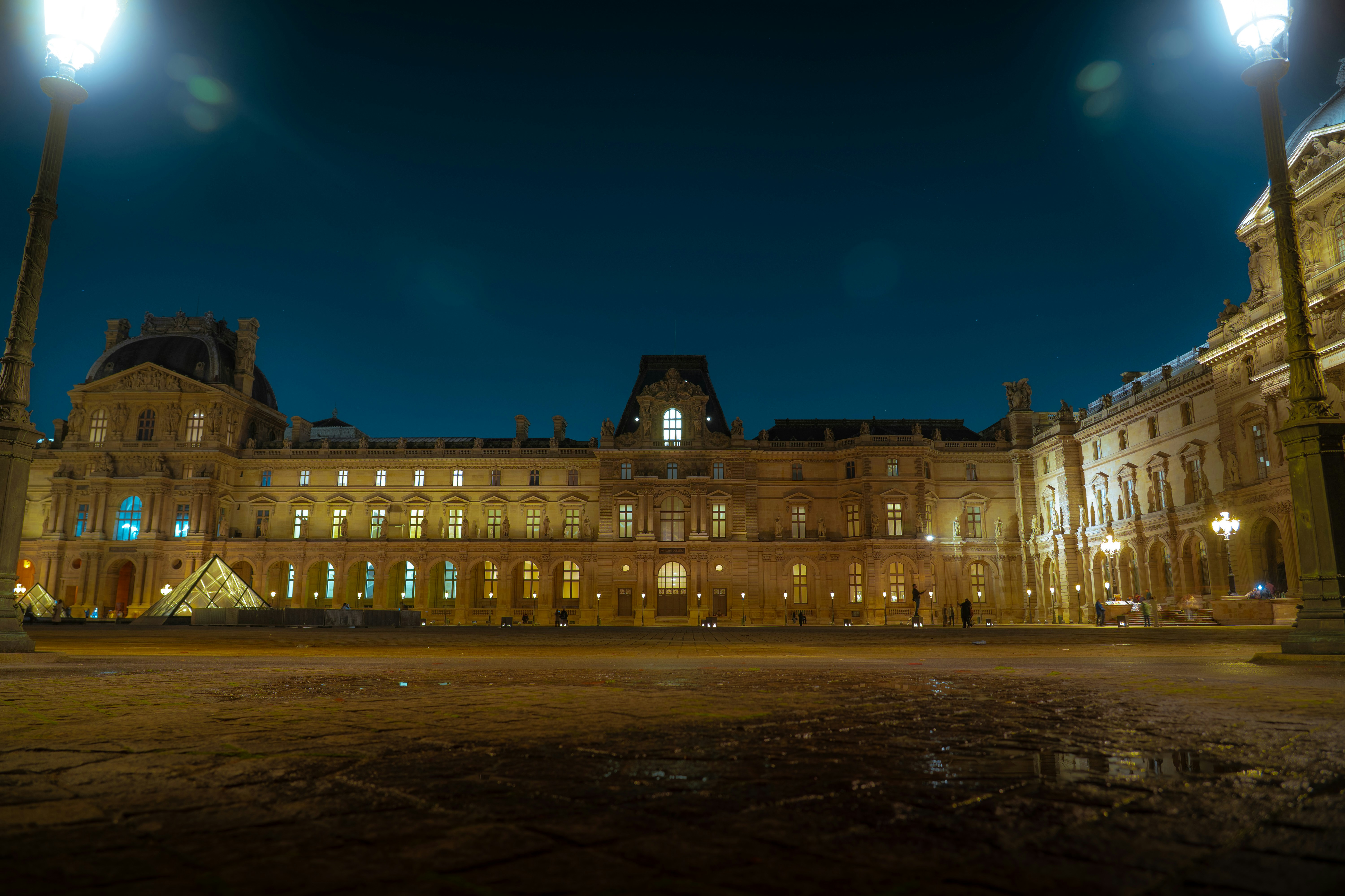 Louvre museum illuminated at night with dark sky
