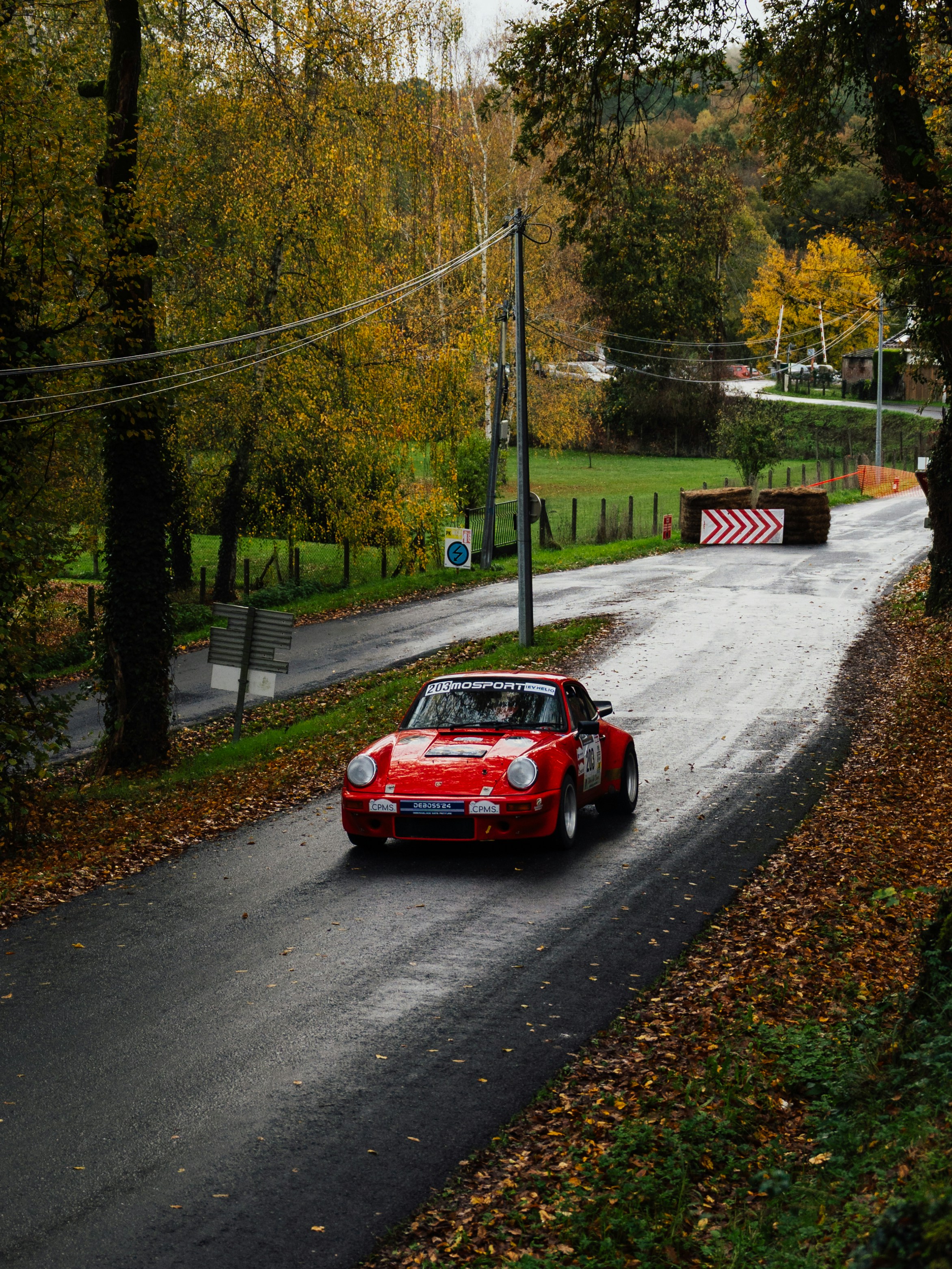 Crimson Porsche Navigates a Rain-Slick Autumn Lane