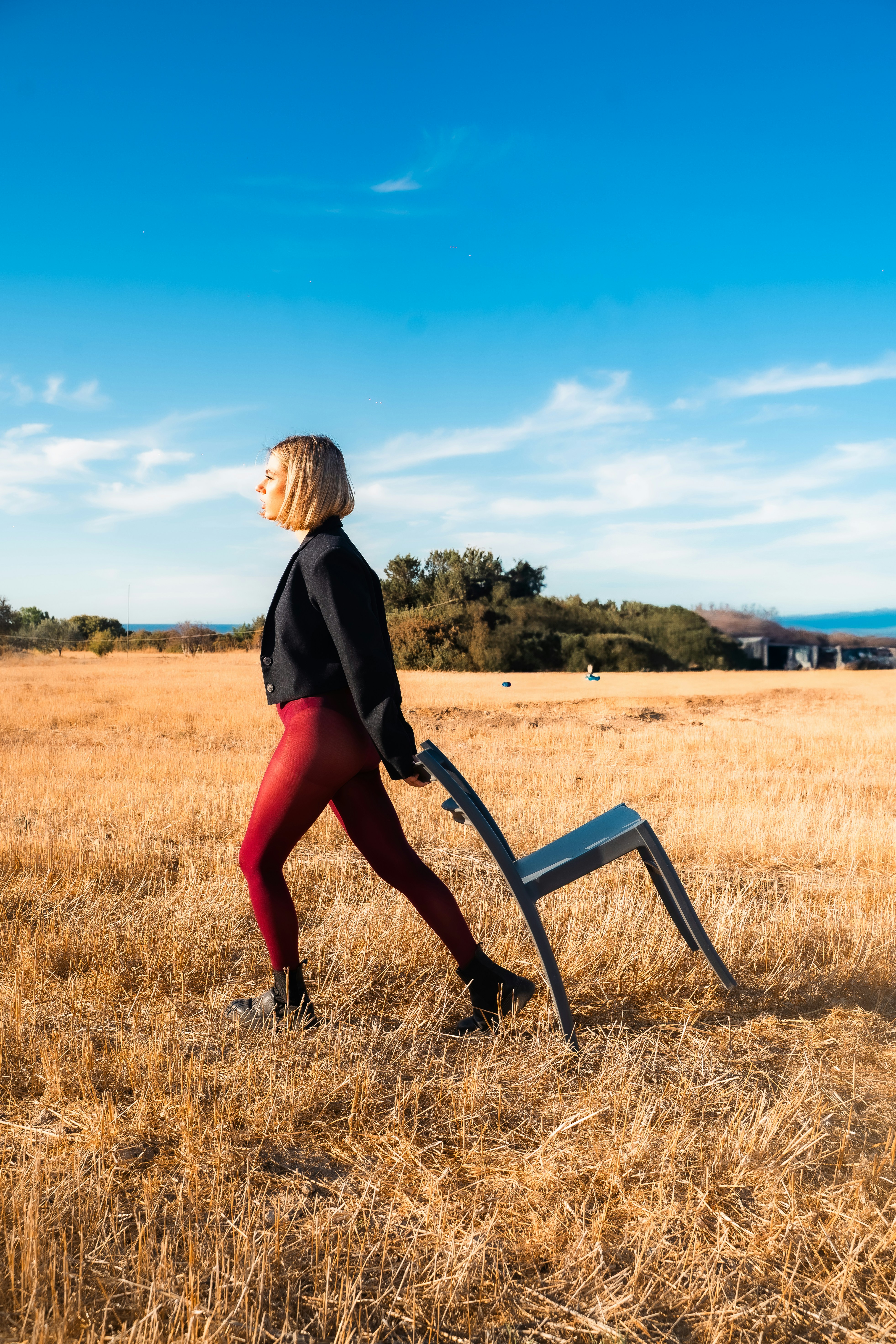 Woman pulling a chair through a dry field photo – Free Portrait Image ...