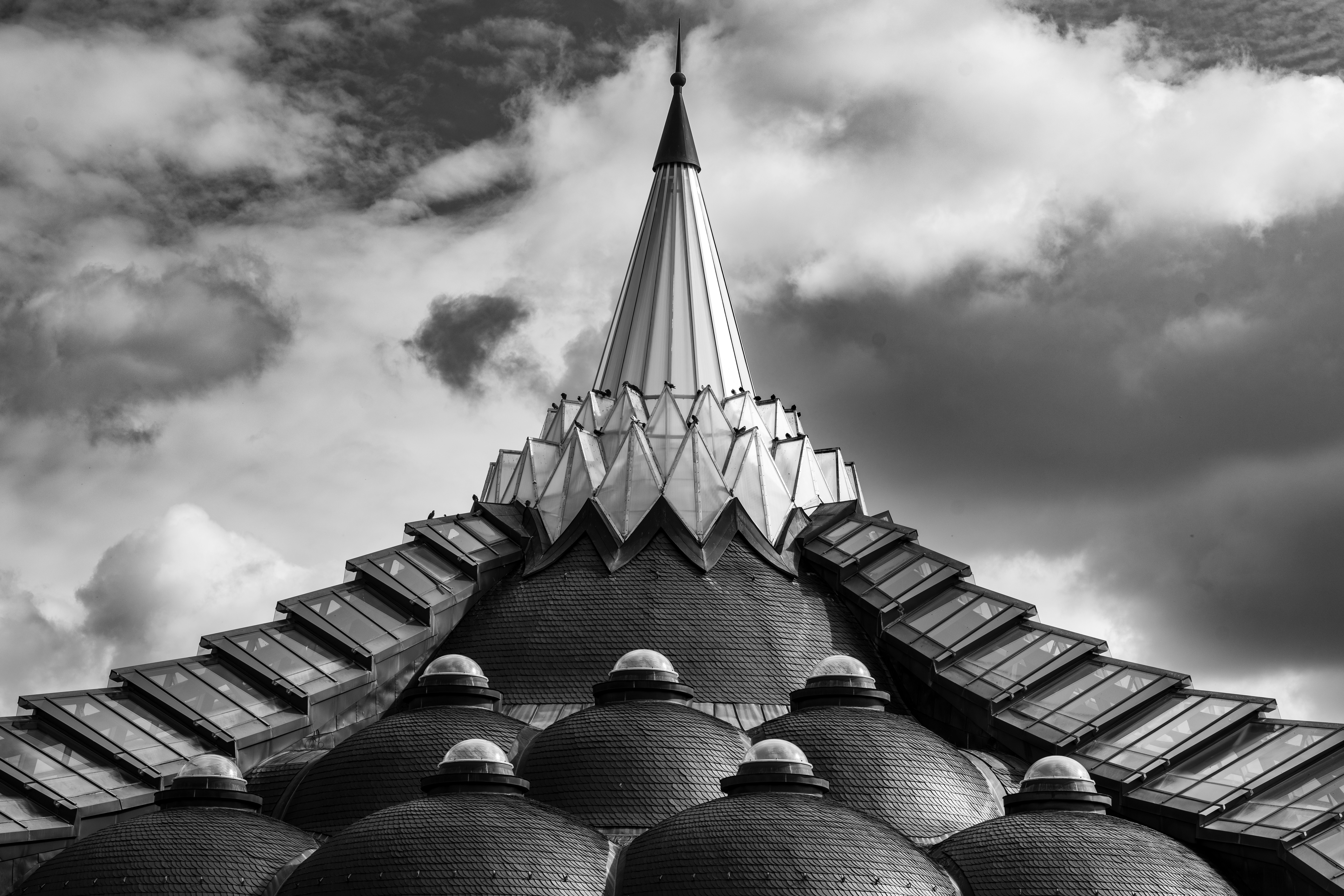 Ornate rooftop with domed structures against cloudy sky