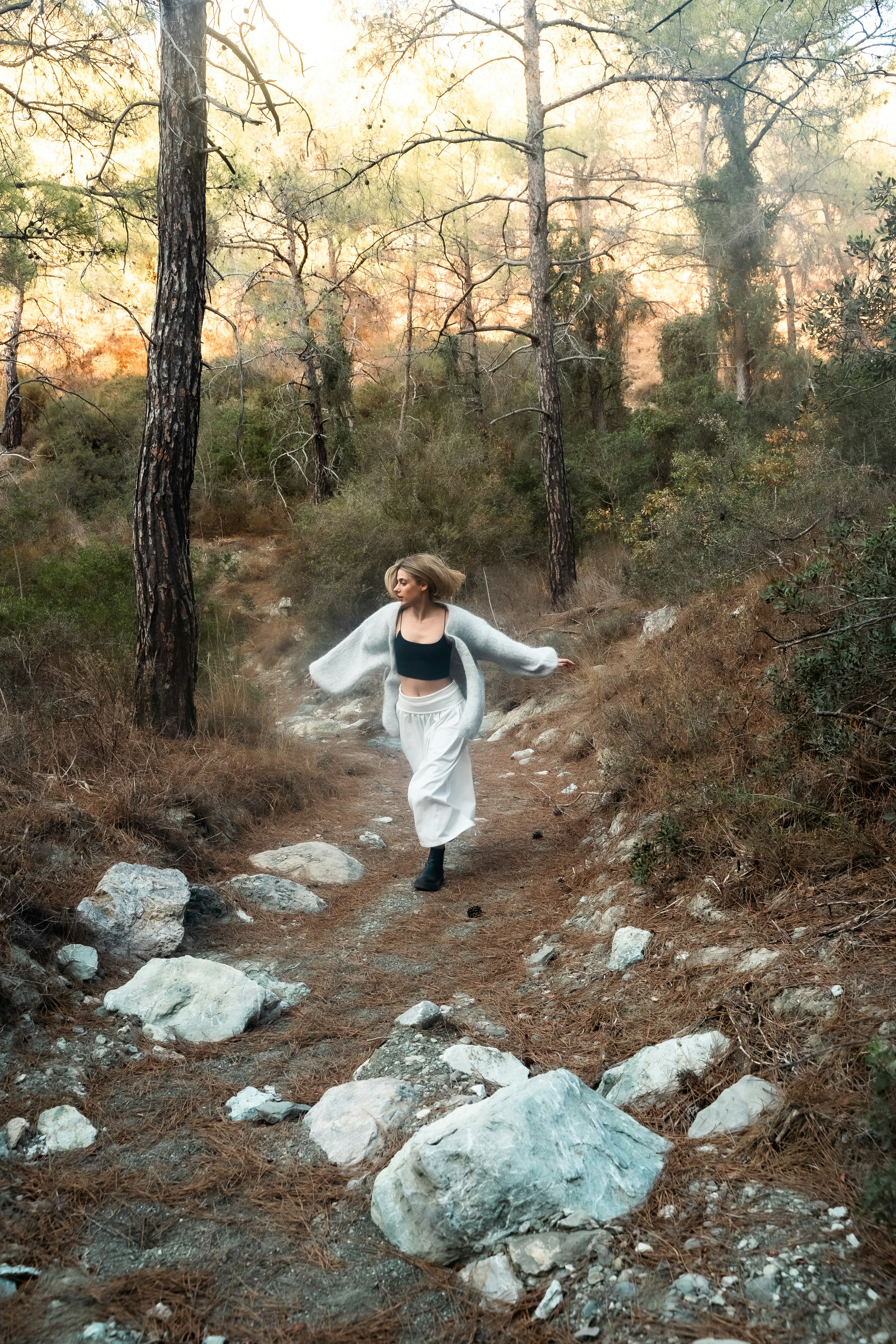 Spinning into Autumn: A Figure Dances Along a Sunlit Forest Path