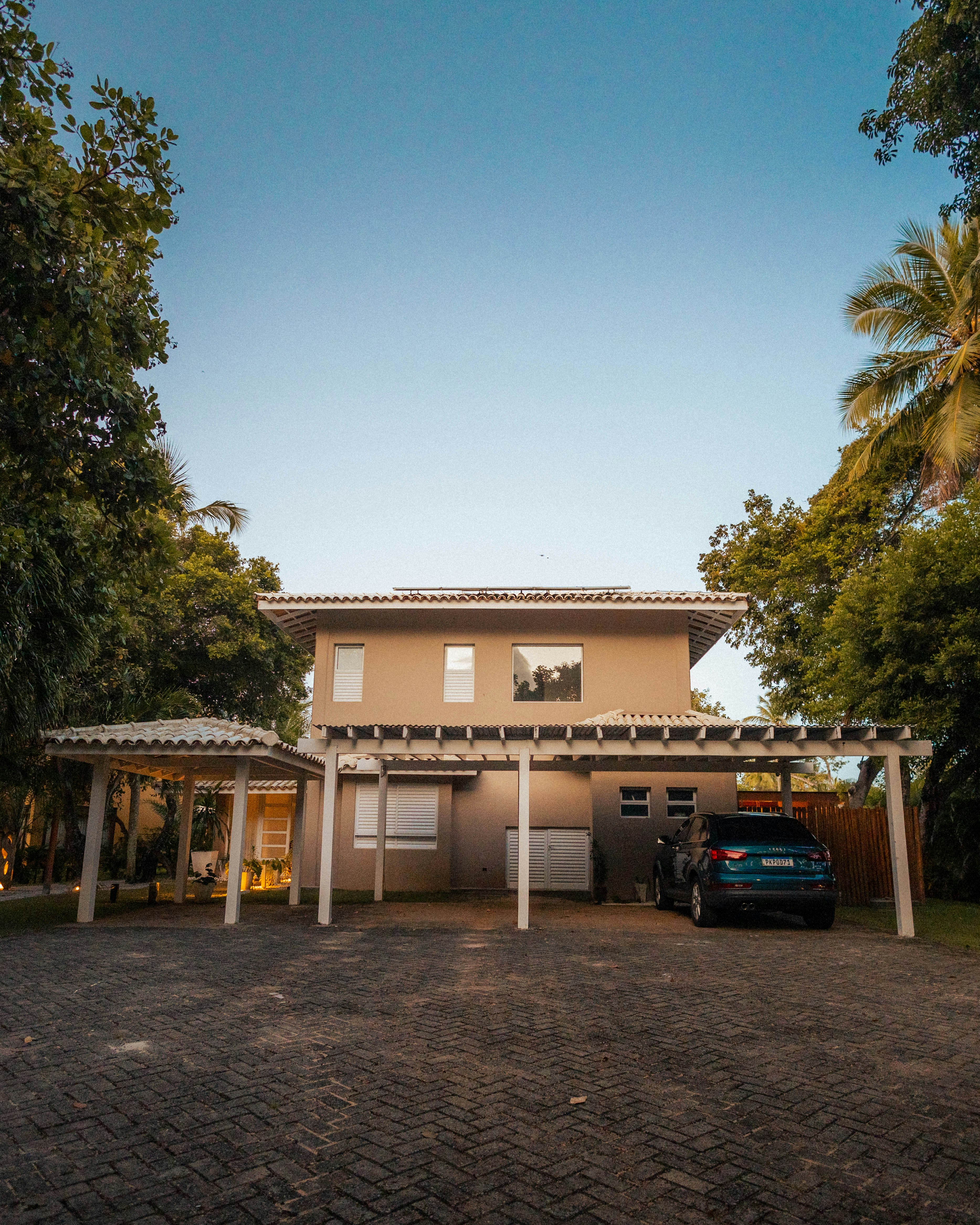 Sunlit Suburban Facade: Beige House under Palm-Shaded Sky