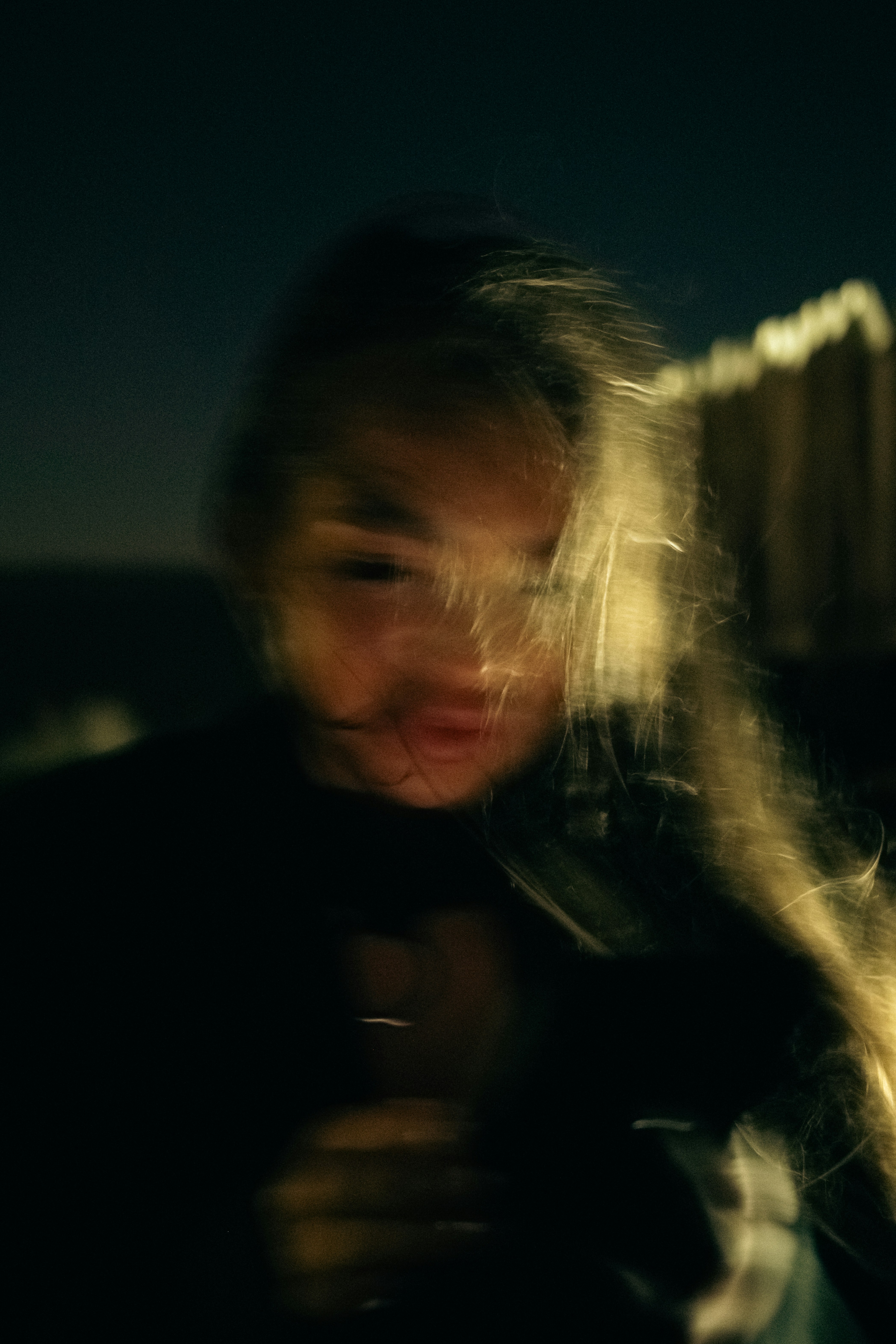 Blurred portrait of a young woman at night