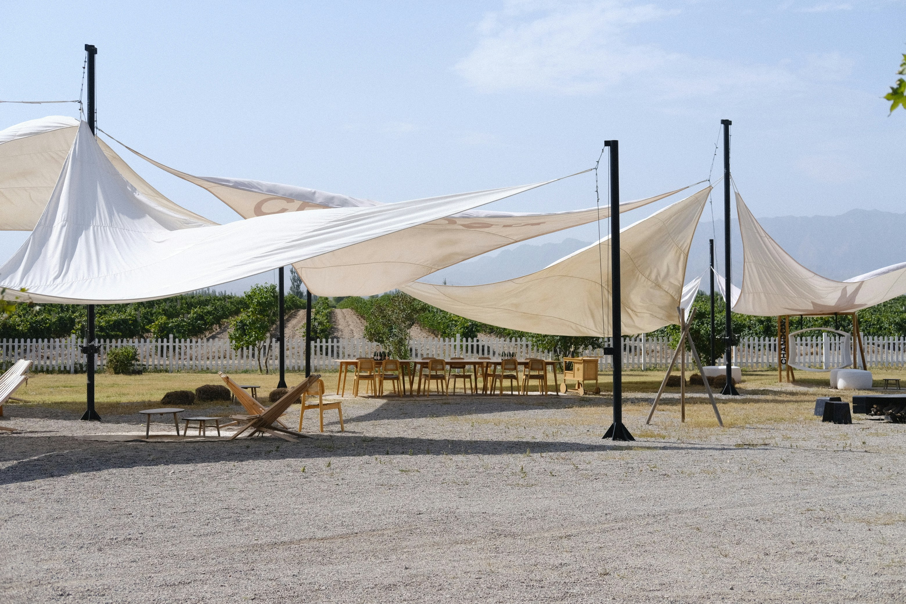 Taut Canvas Canopies Over a Gravel Terrace Lounge