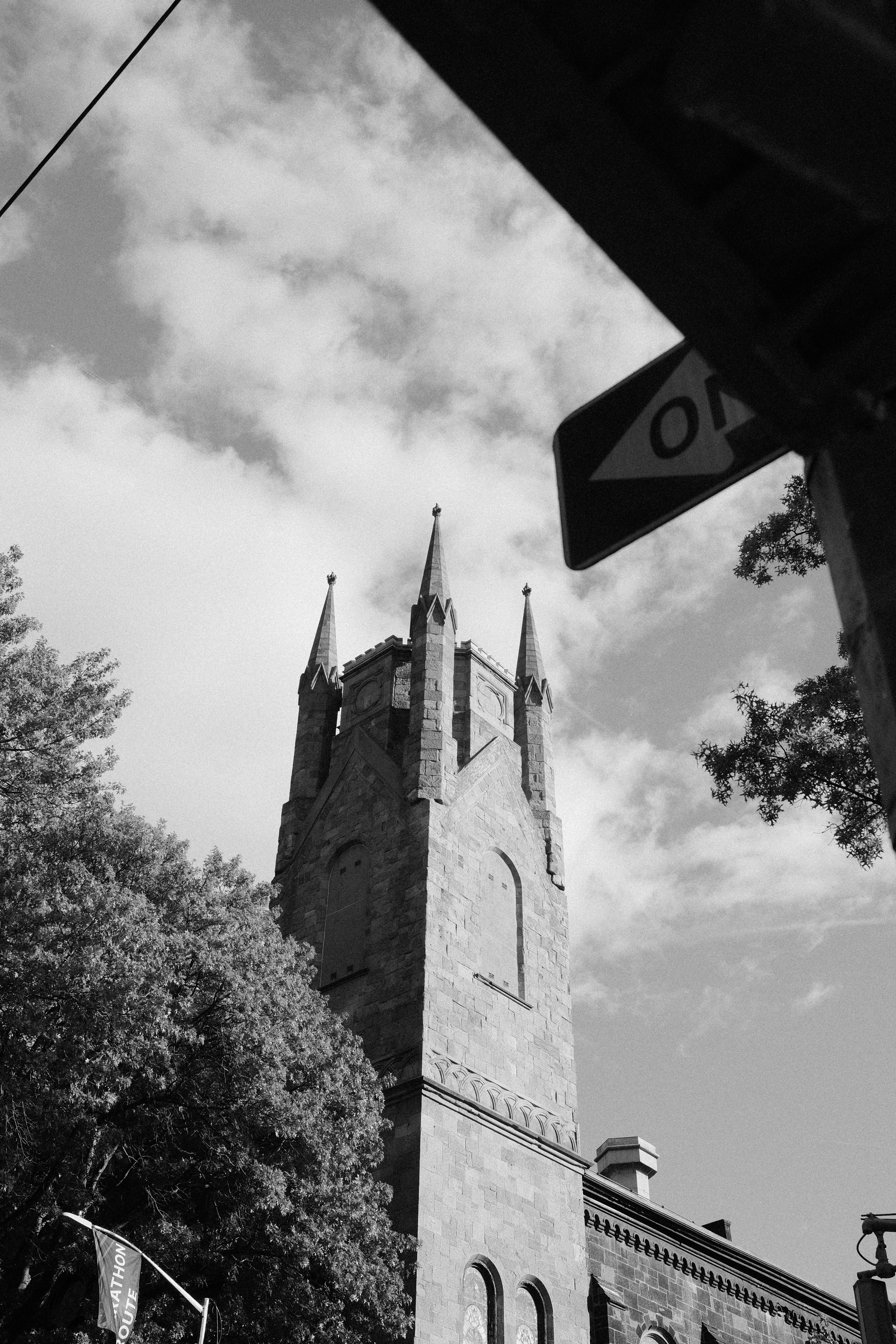 Stone church tower with spire against sky.