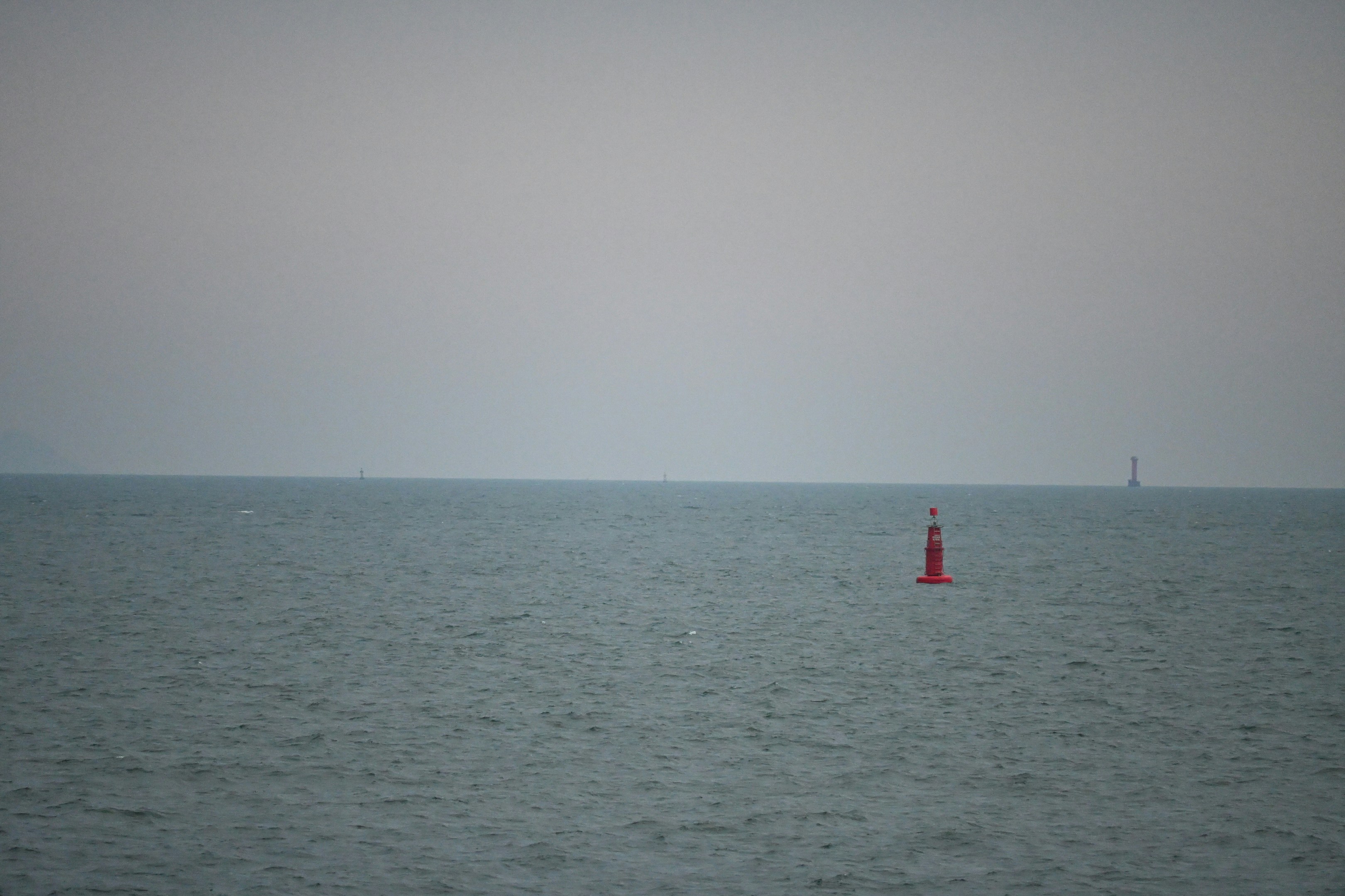 Red Buoy at the Edge of Quiet Seas